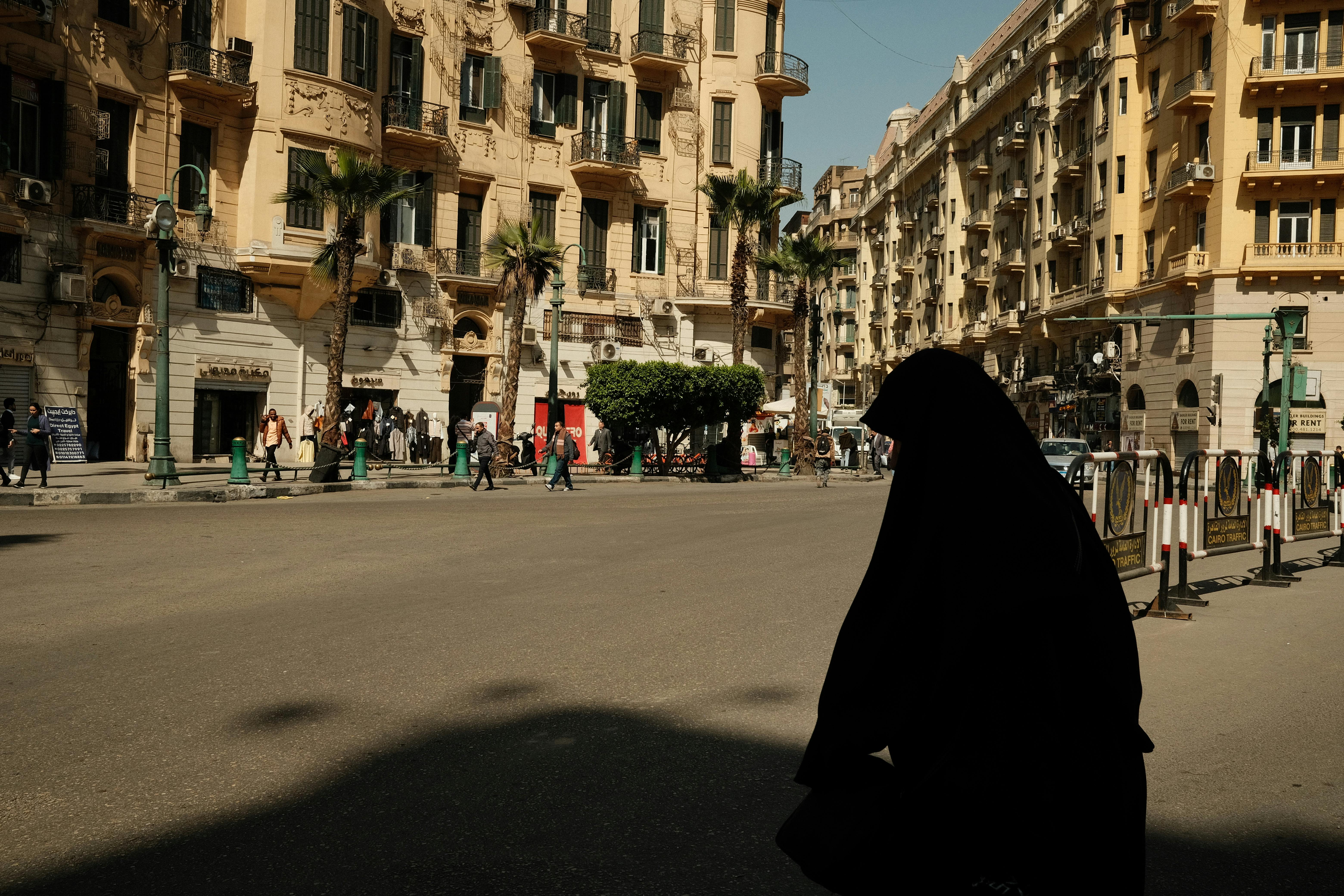 Person in Hood Standing in Shadow on Street in City · Free Stock Photo