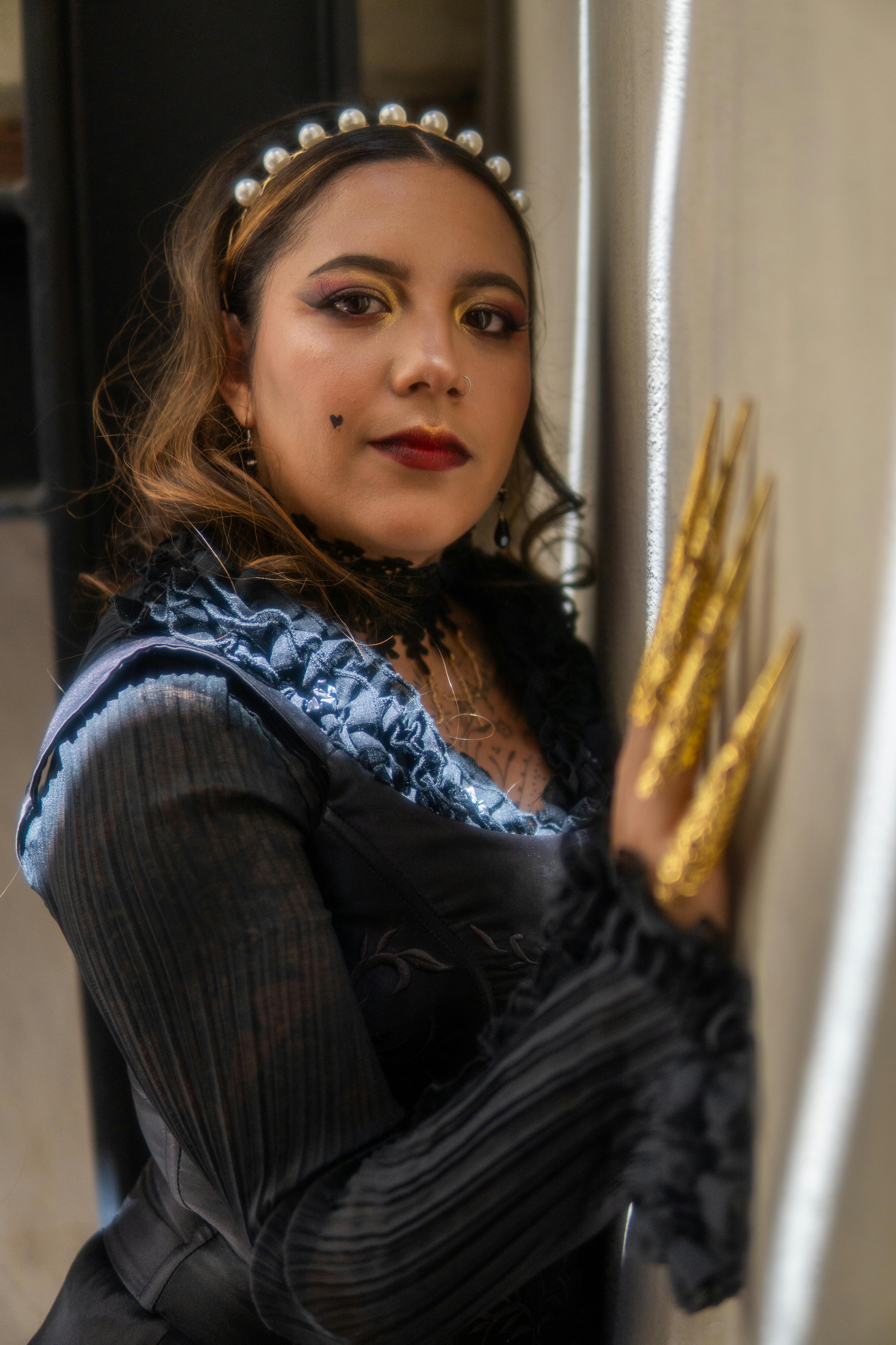 Woman in a Costume and Finger Claws Posing by the Wall · Free Stock Photo