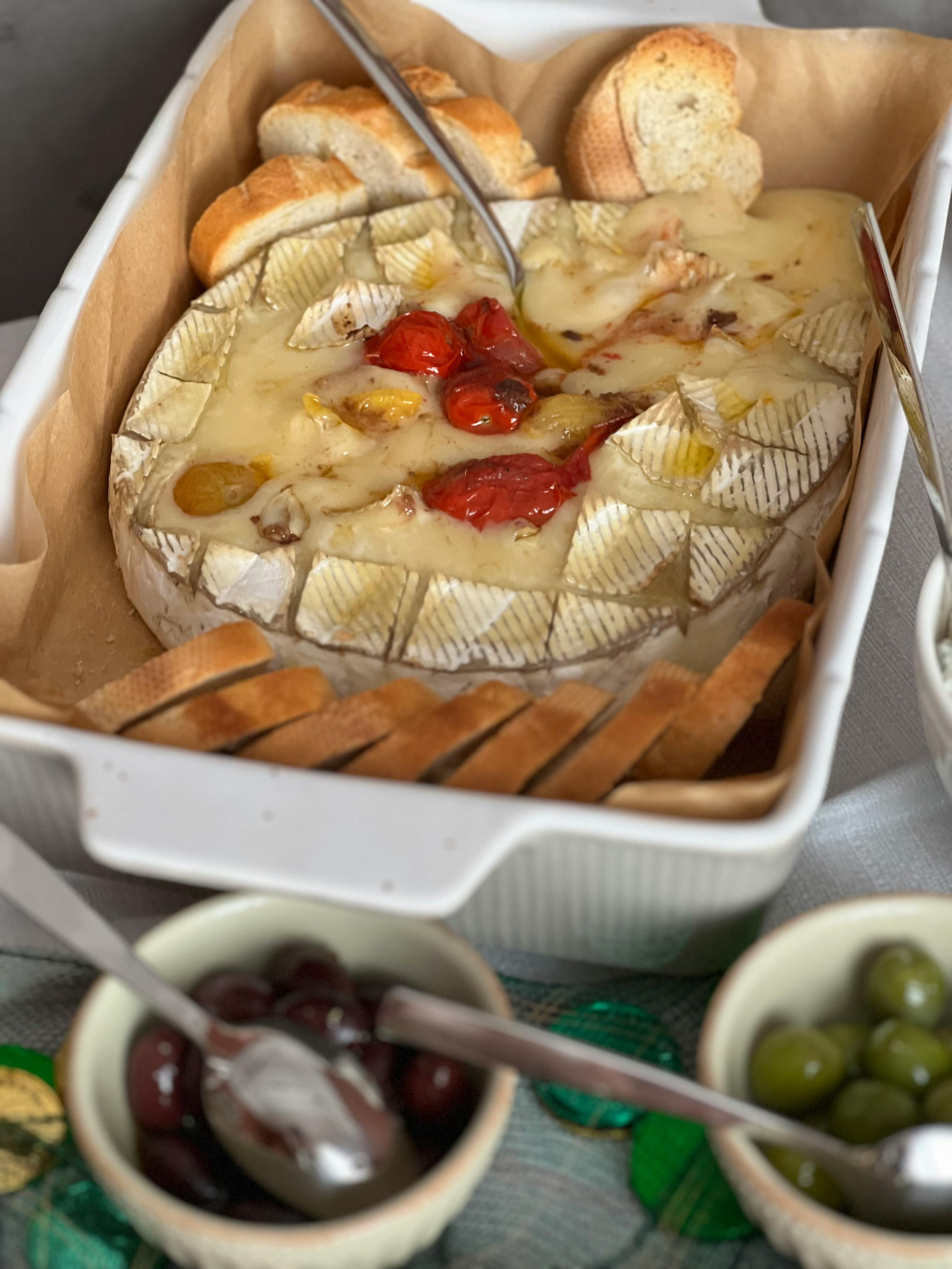 Close-up of a Baked Camembert Cheese Served with Bread and Olives ...