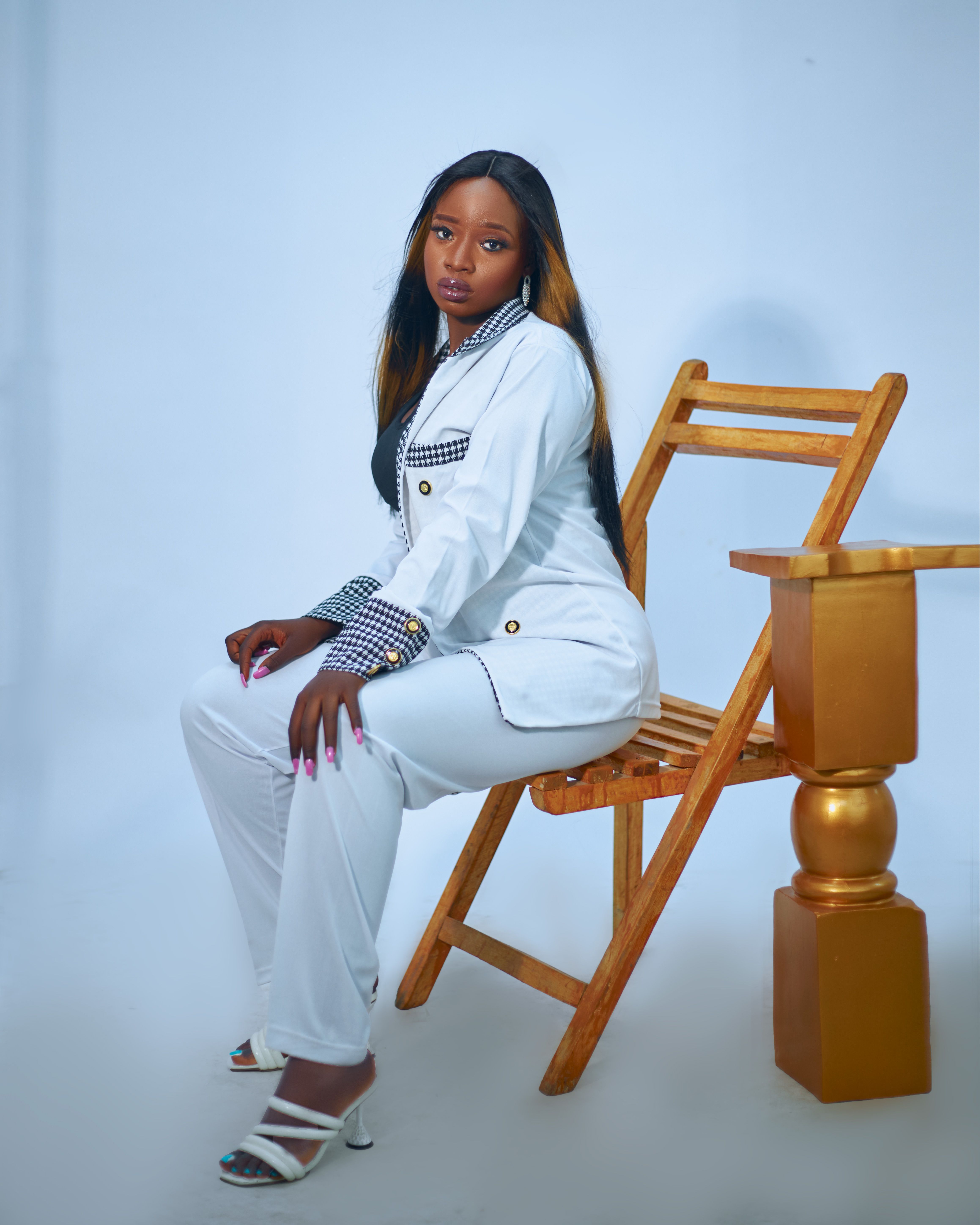 Beautiful Woman in White Jacket and Pants Sitting on Wooden Chair in ...