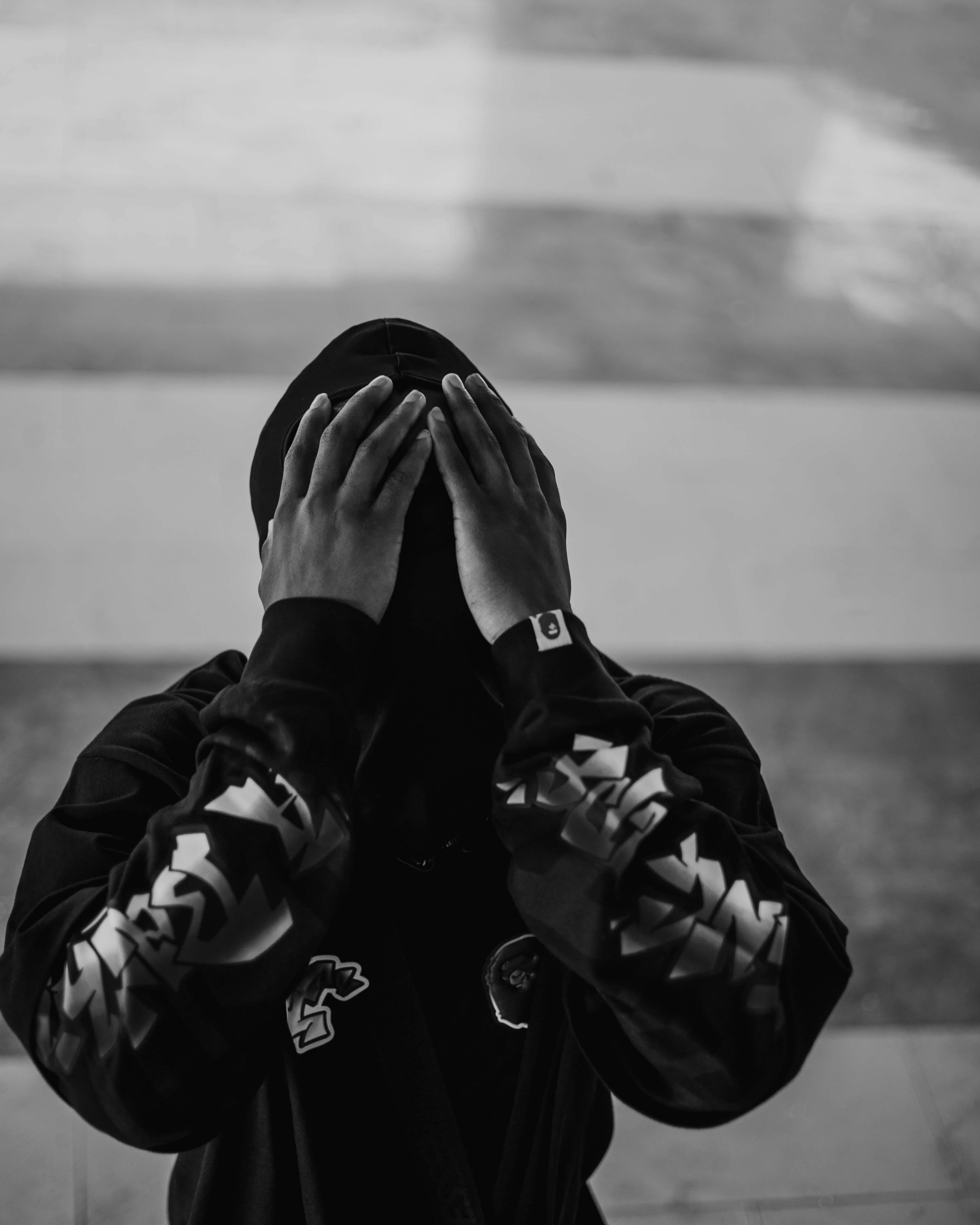 A person in a hoodie covering their face · Free Stock Photo