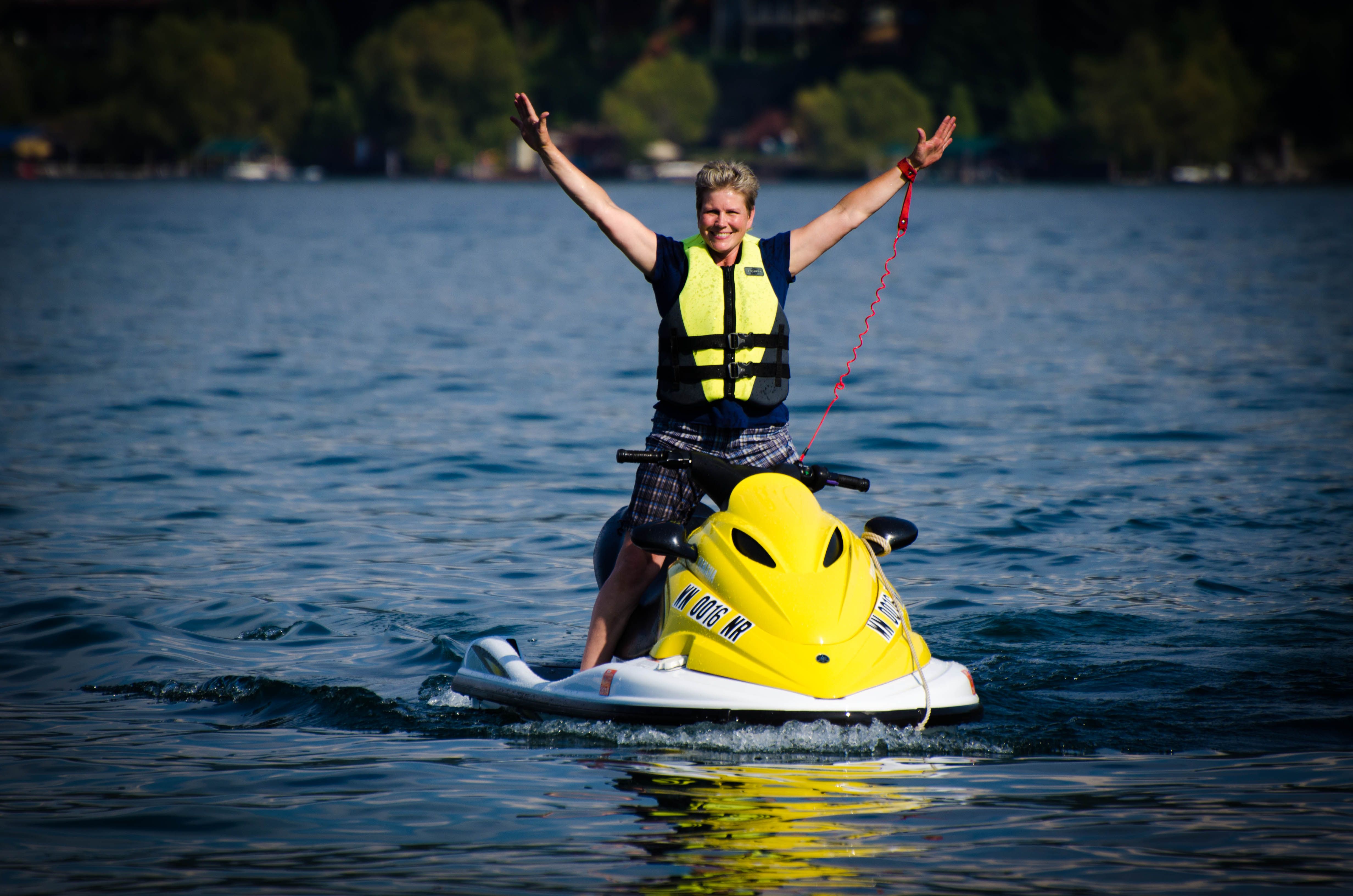 Woman Posing with Arms Raised on Jet Ski · Free Stock Photo