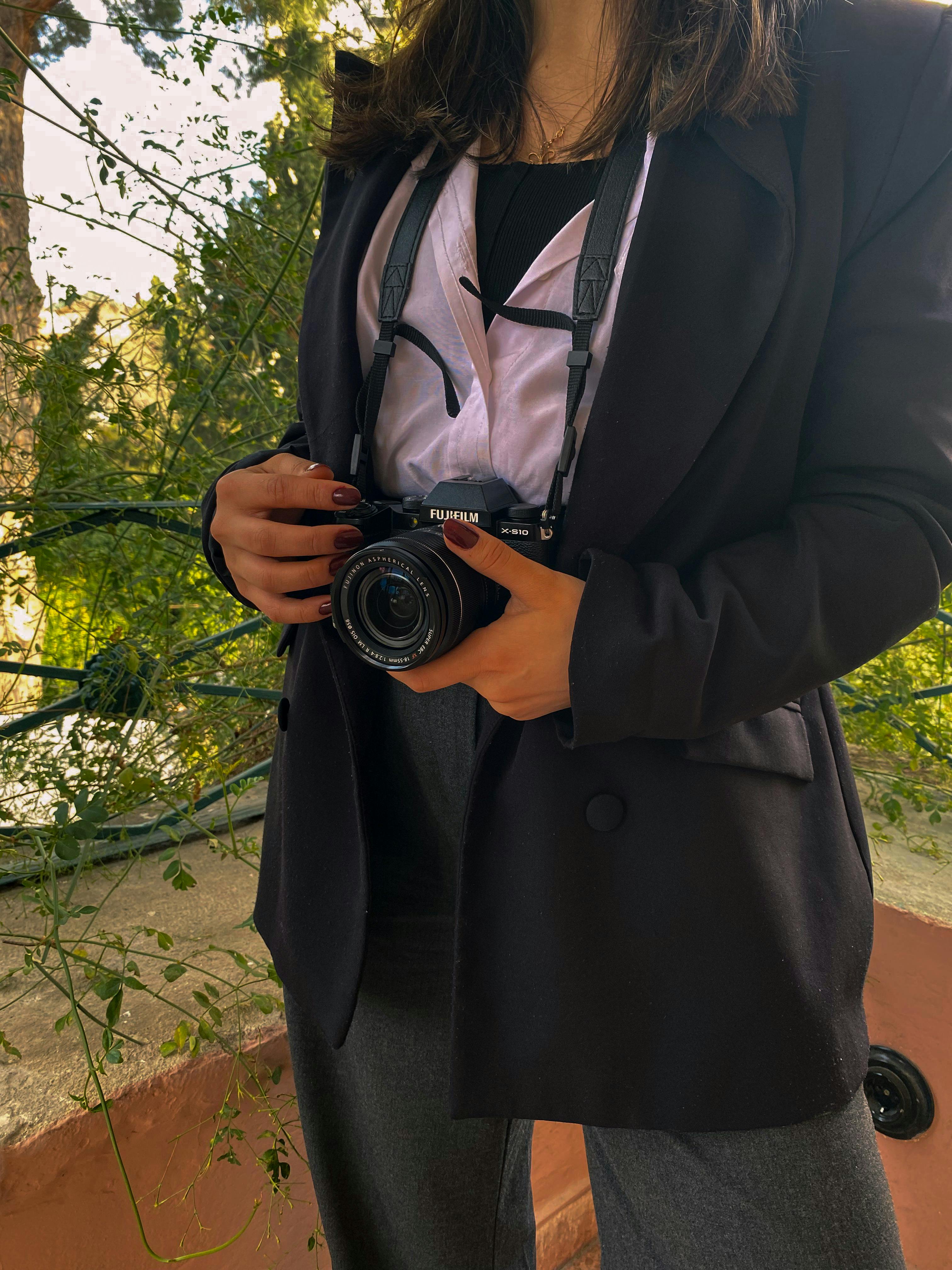 Woman in Black Suit Standing with Camera · Free Stock Photo
