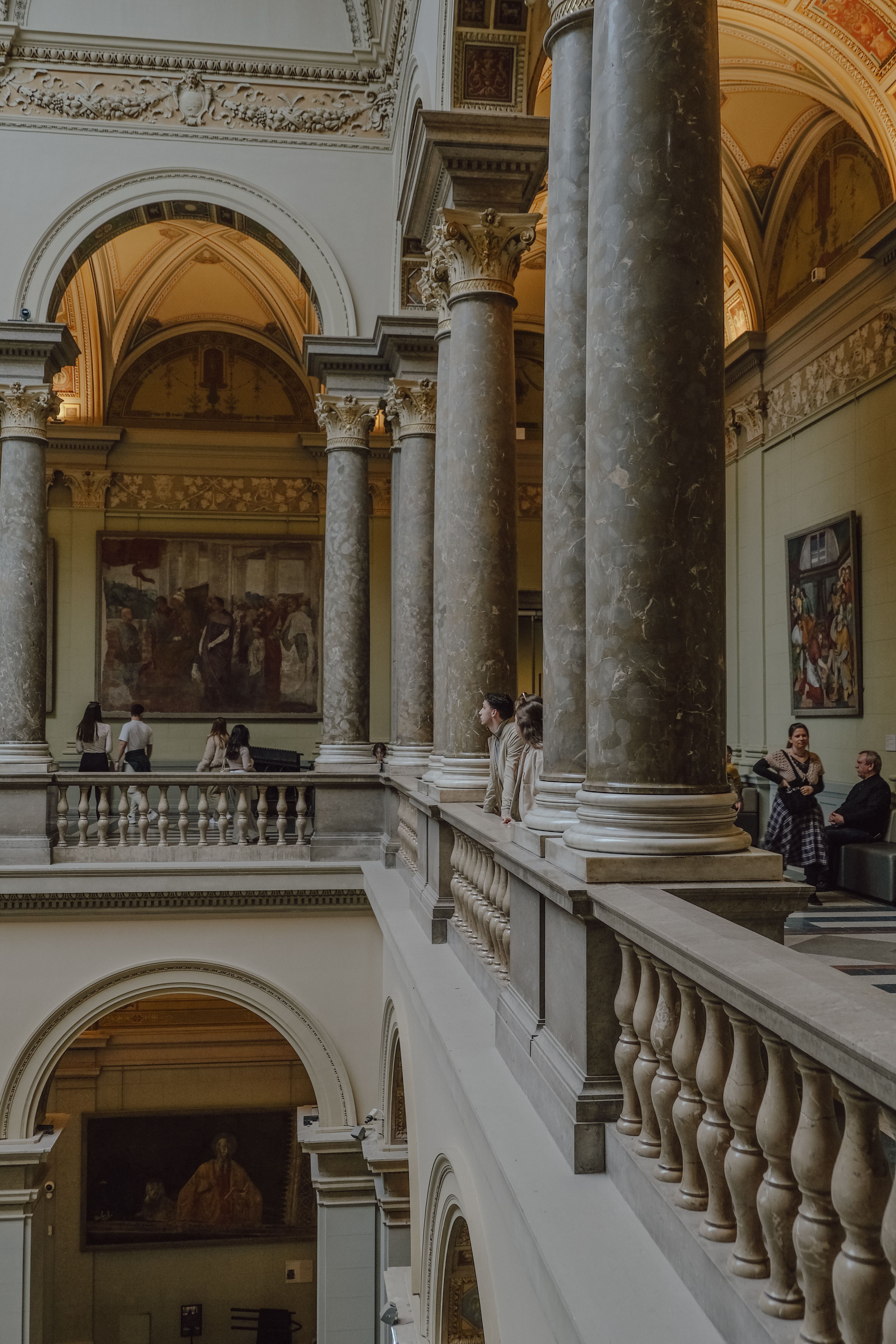 People are walking through a building with columns · Free Stock Photo