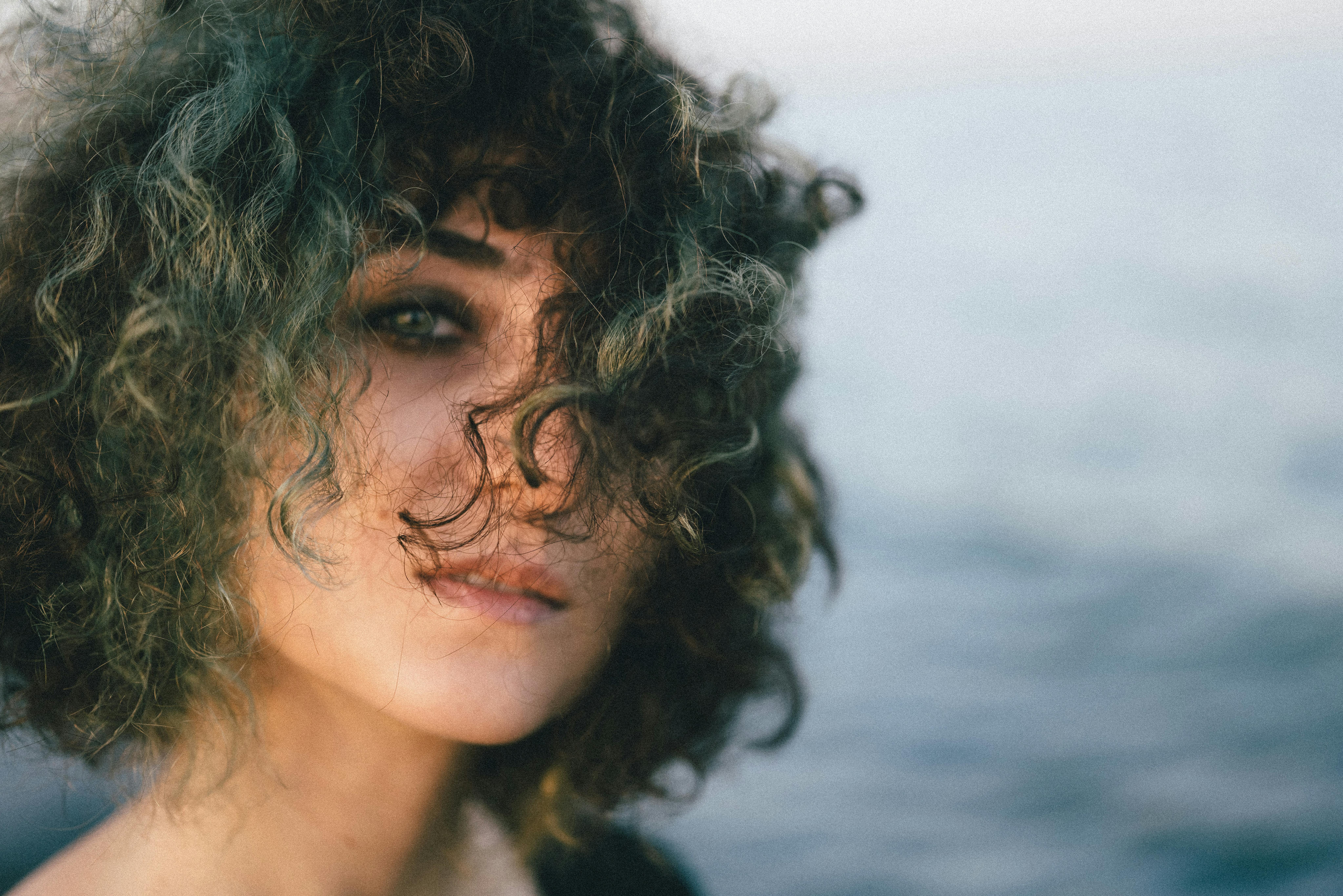 Photo of a Young Woman with Curly Tousled Hair · Free Stock Photo