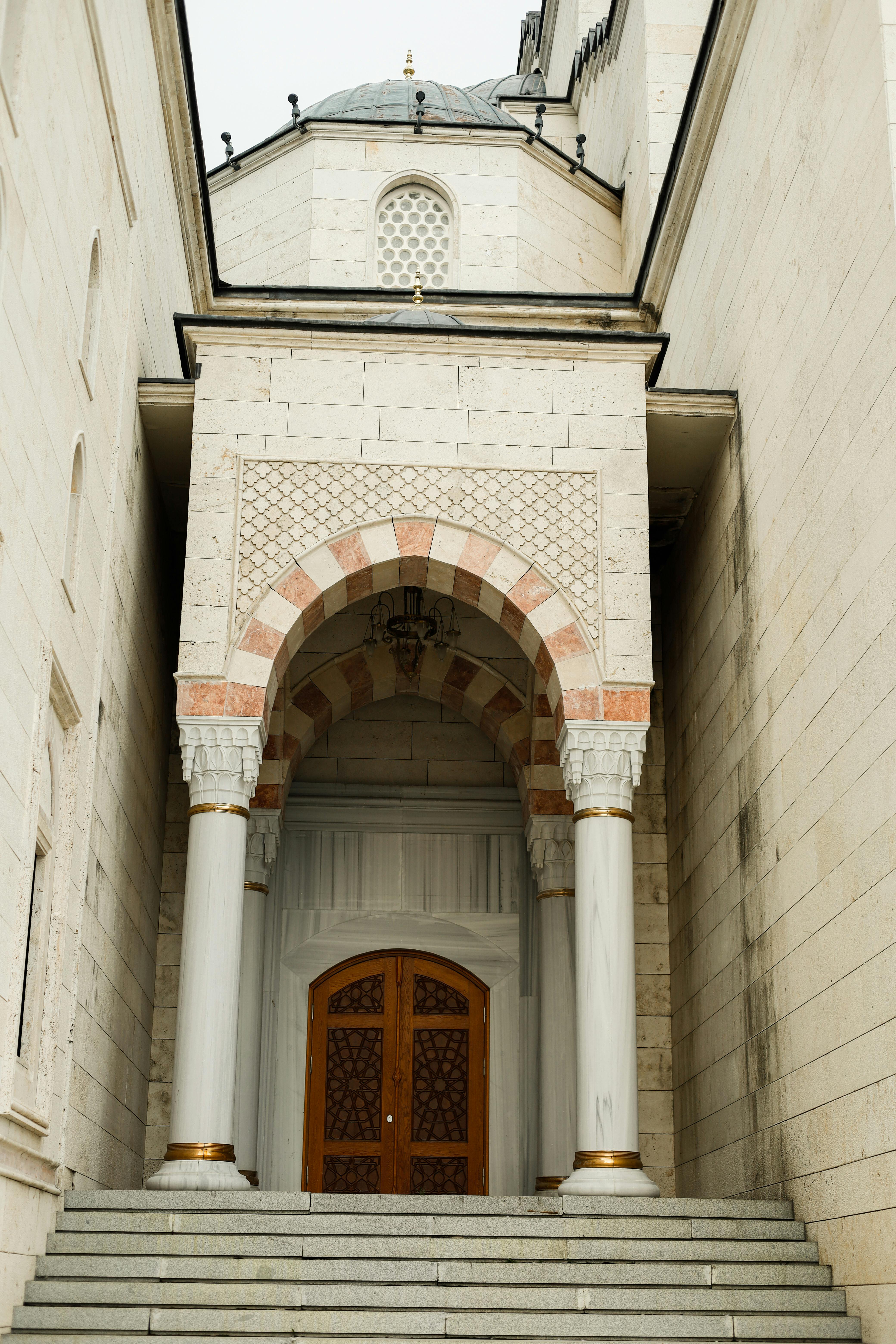 The entrance to a building with arches and columns · Free Stock Photo