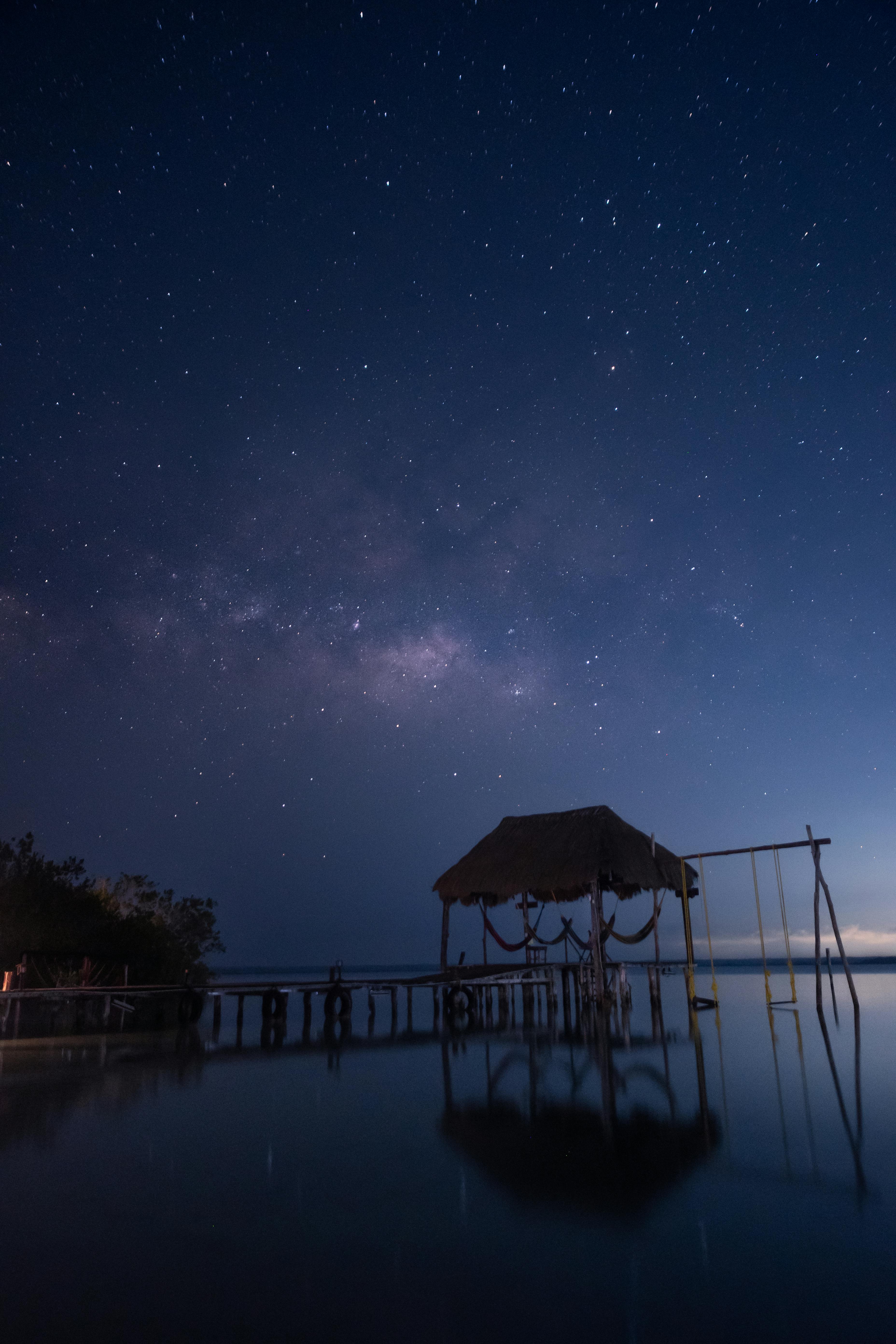 Stars on Night Sky over Ocean Coast with Swings · Free Stock Photo