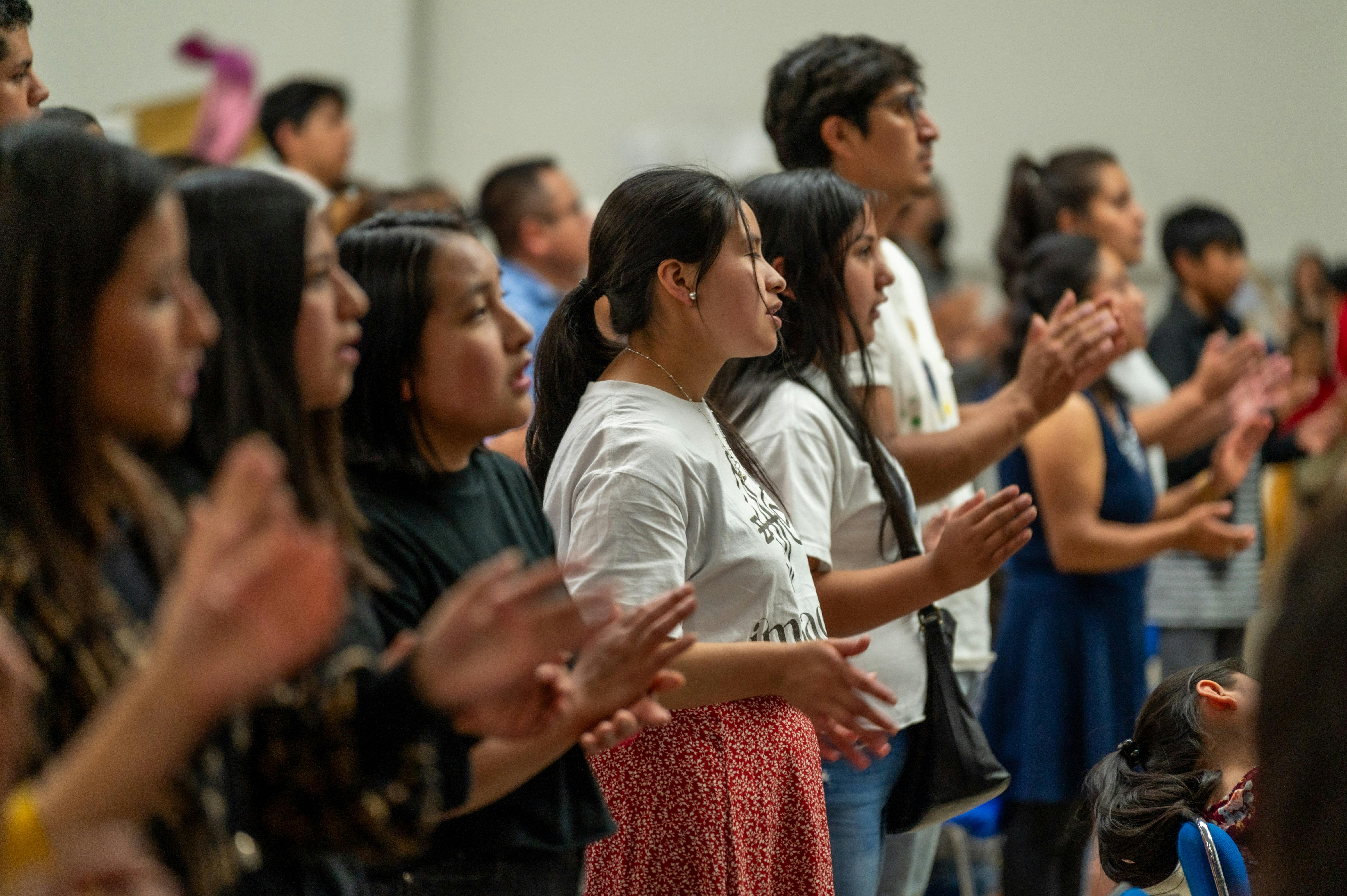 A group of people clapping in a room · Free Stock Photo