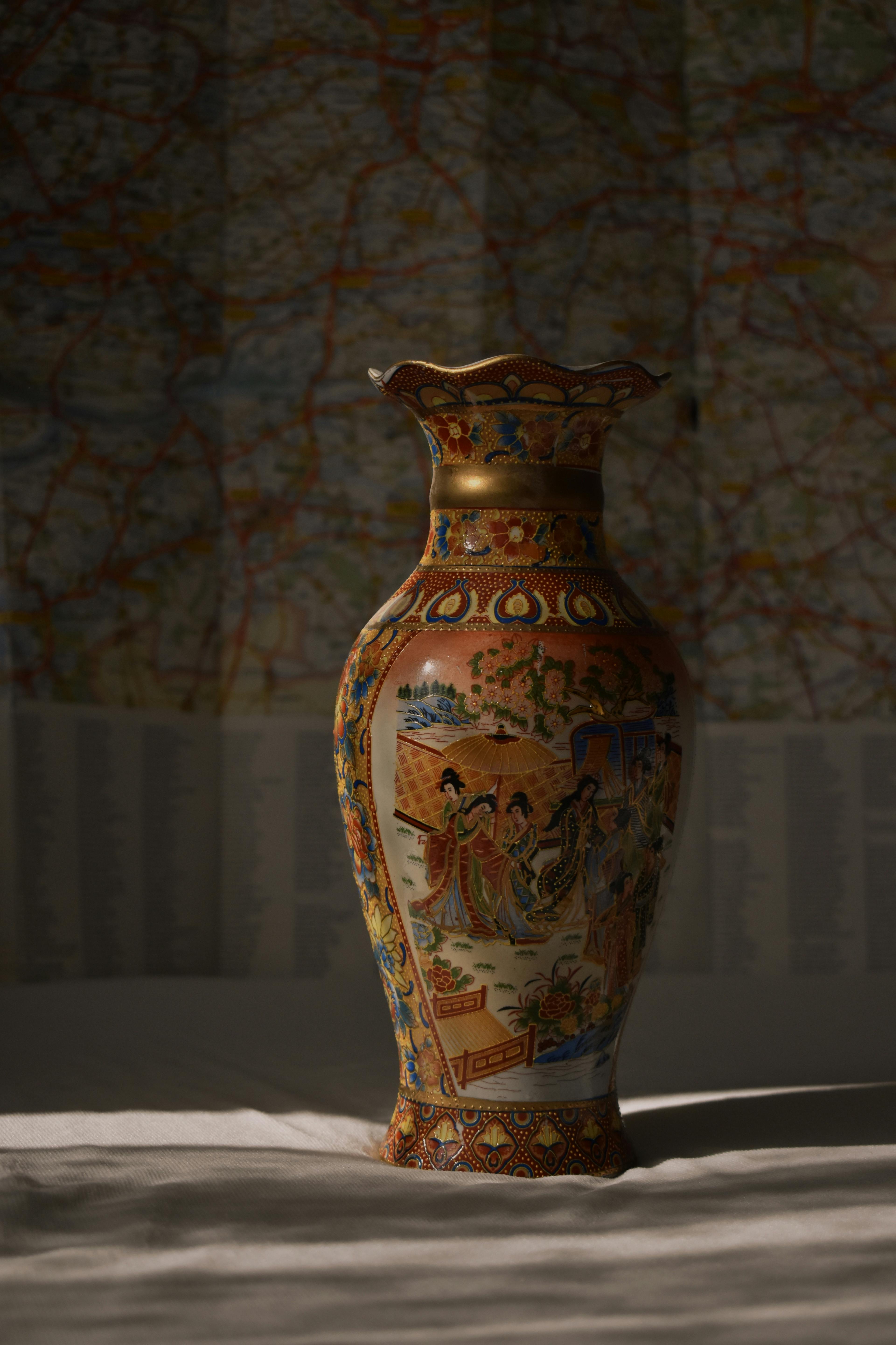 A vase on a table with a map behind it · Free Stock Photo