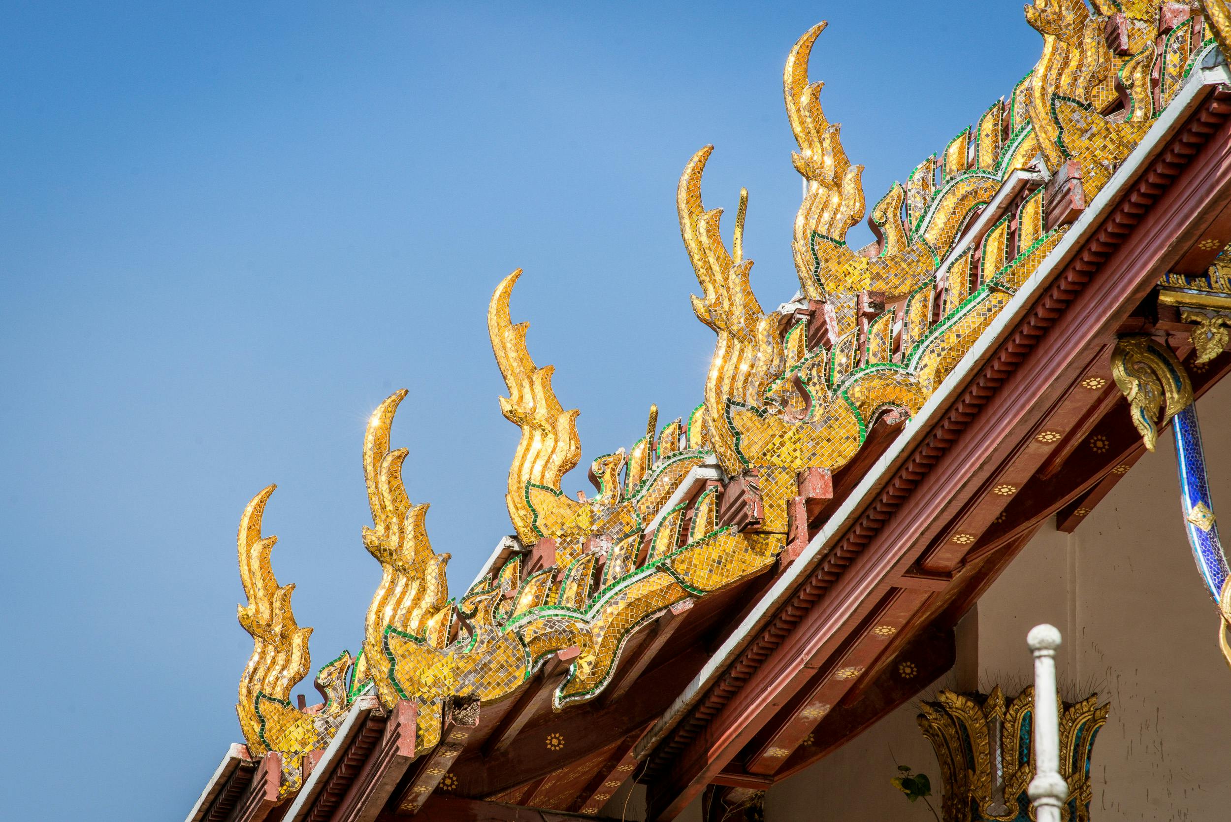 Golden roof of a temple with blue sky in the background · Free Stock Photo