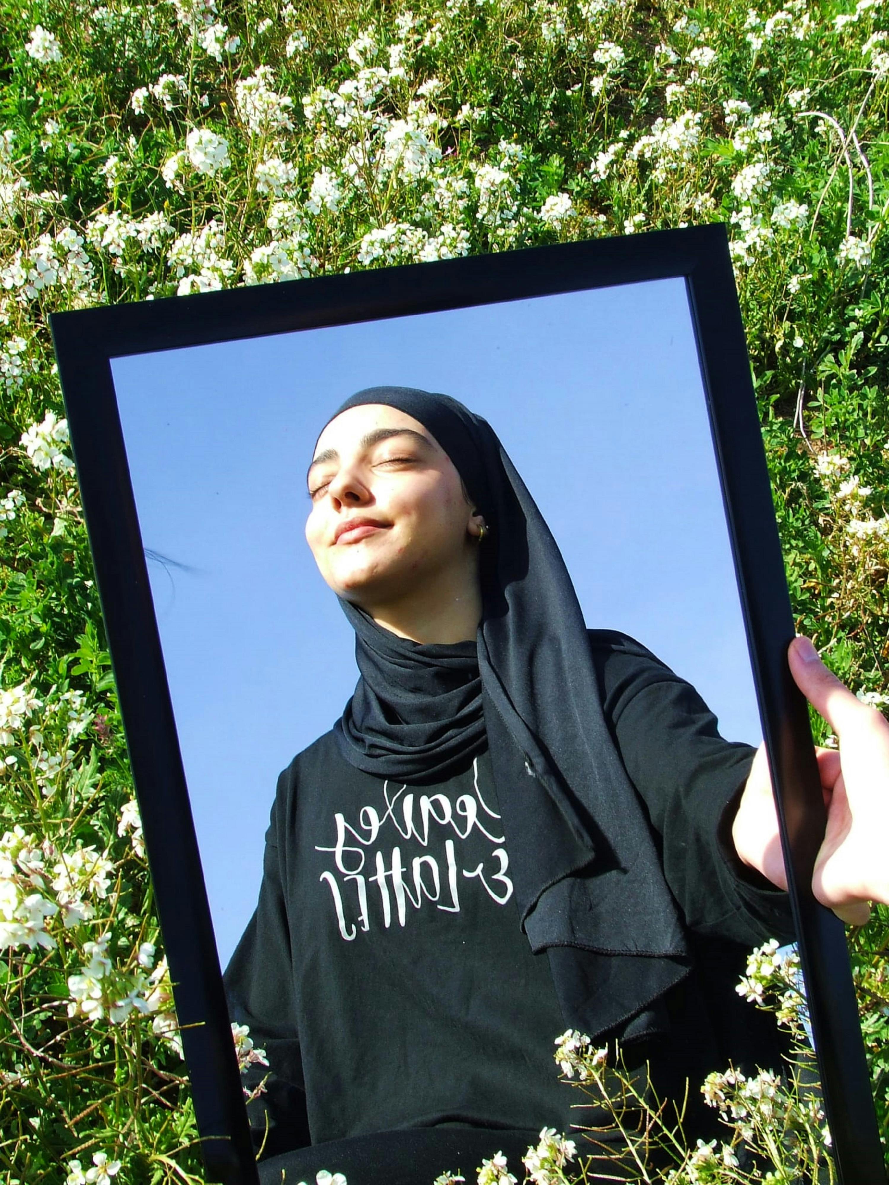 Reflection in Mirror of Woman in Hijab on Meadow · Free Stock Photo