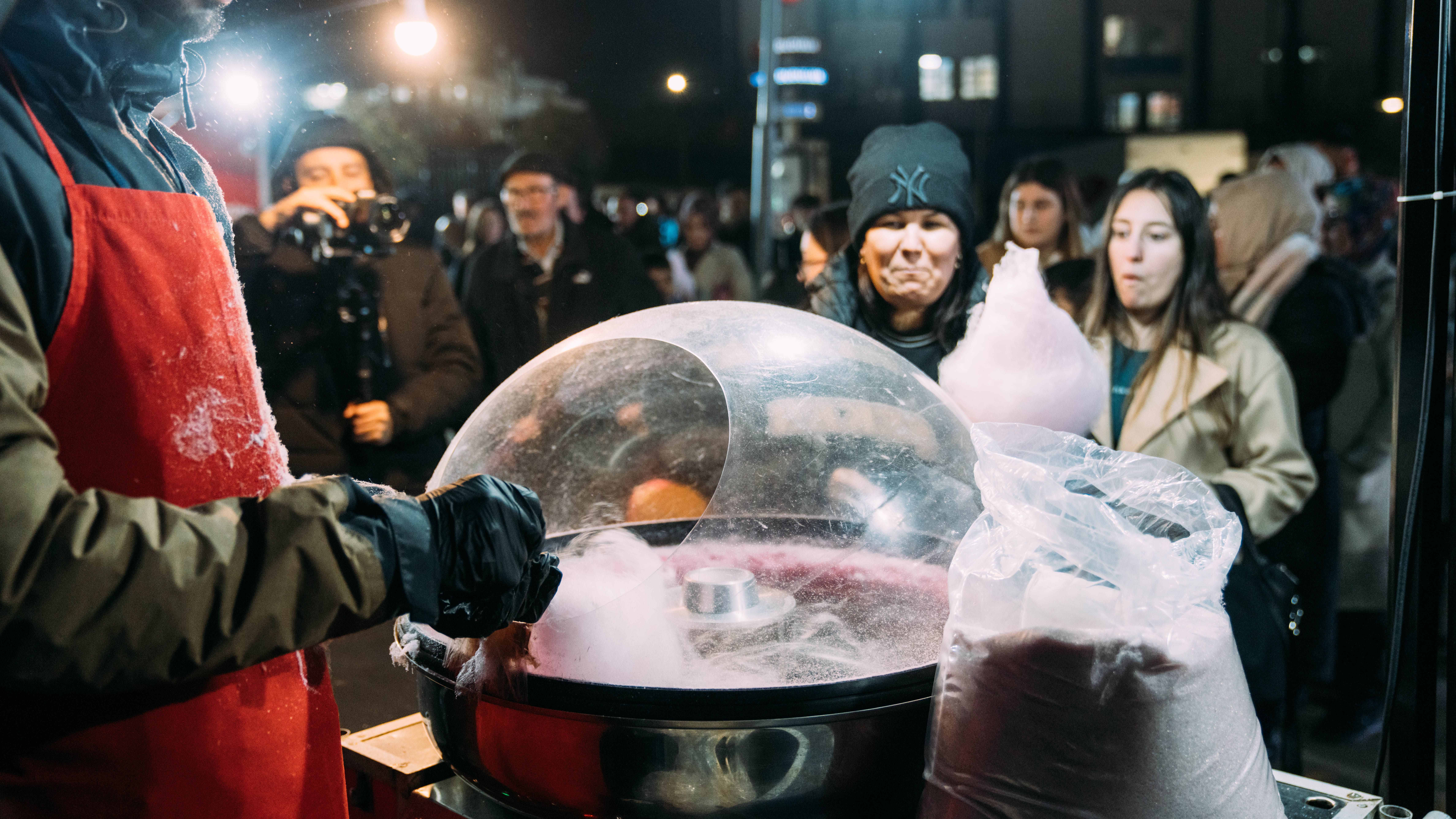 People Standing around Man Making Cotton Candy · Free Stock Photo