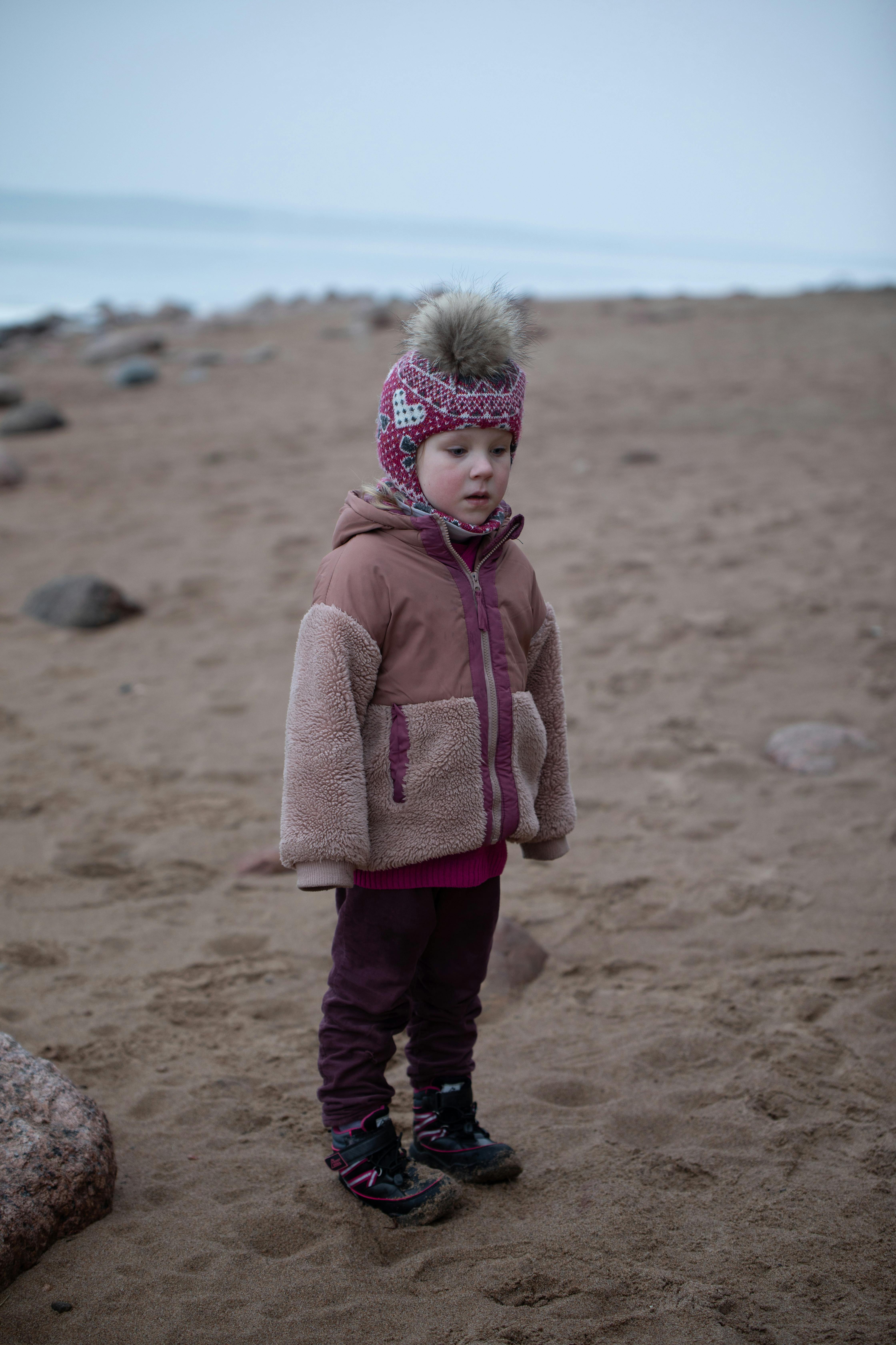 Child in Jacket and Hat in Cold Seaside · Free Stock Photo