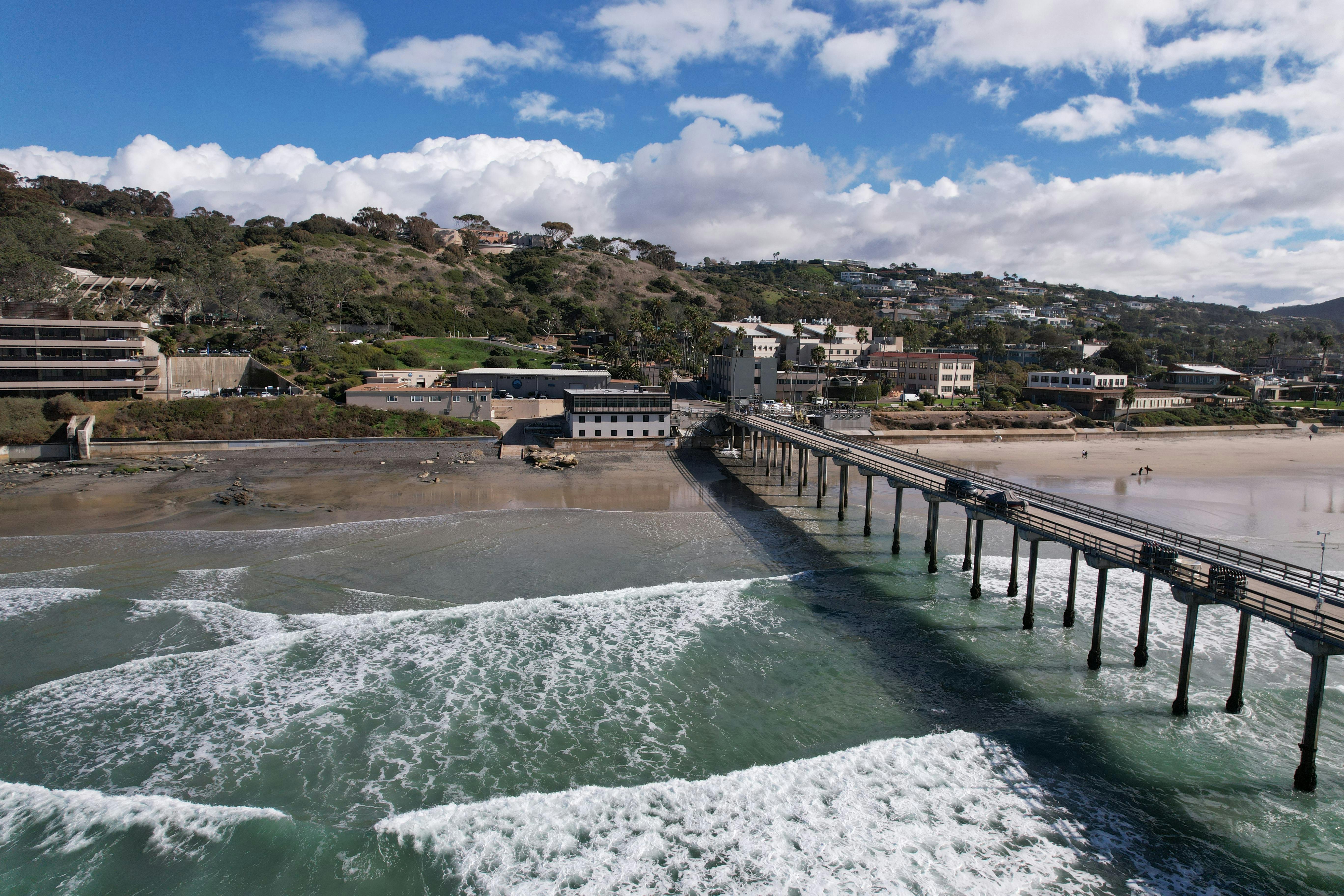 Bridge with Pillars and Waves on the Shore · Free Stock Photo