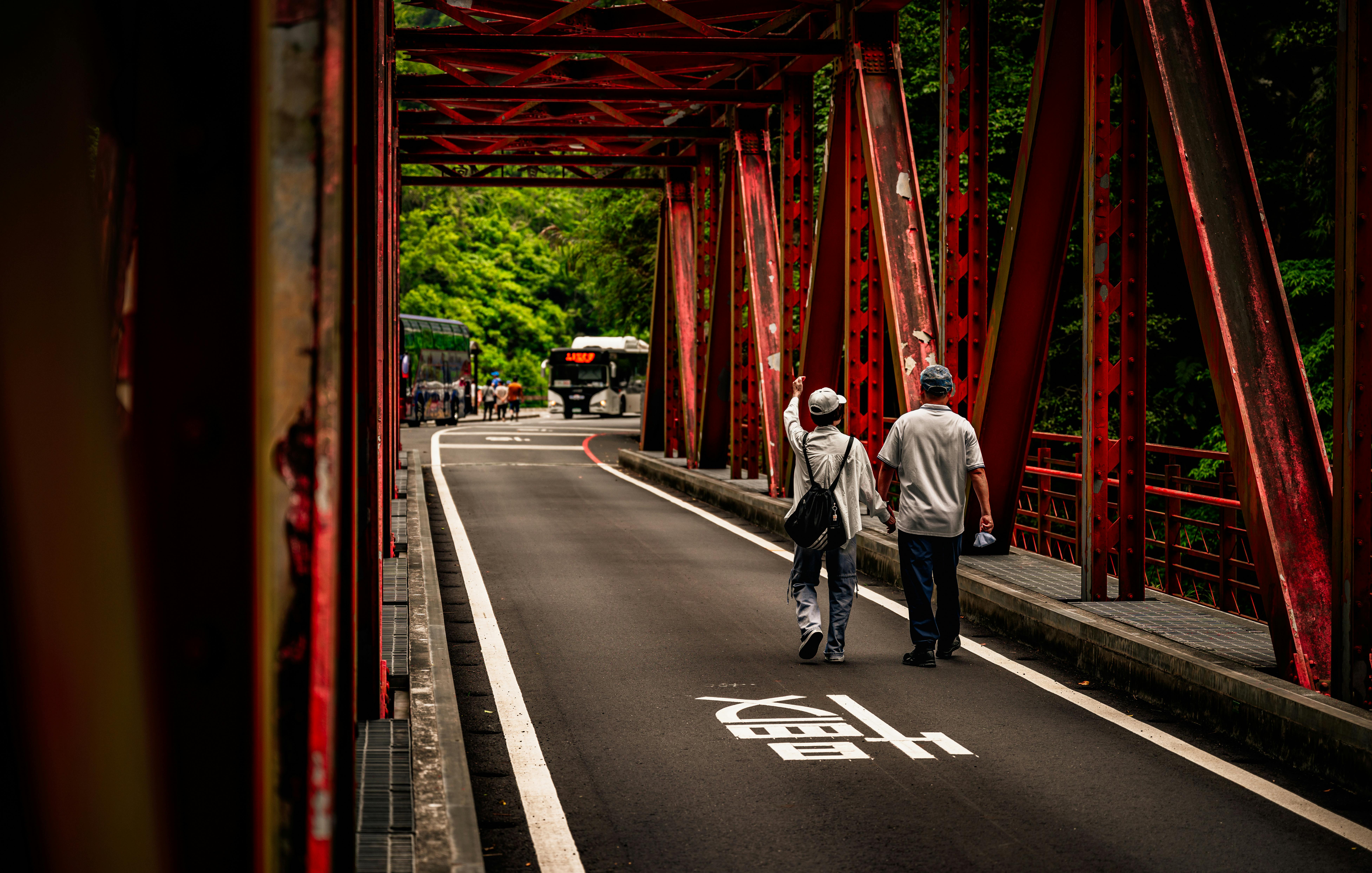 People crossing a red bridge · Free Stock Photo