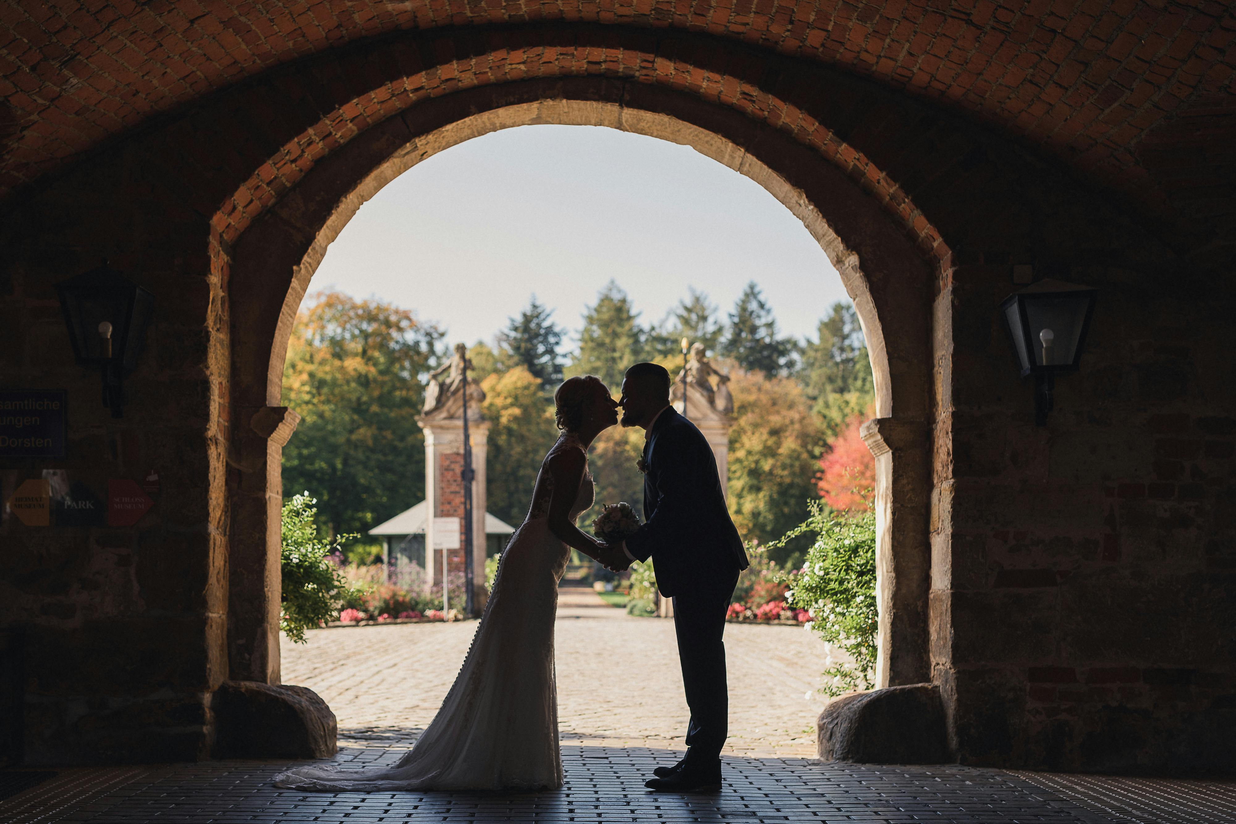 Silhouettes of the Bride and Groom Standing under an Archway · Free ...