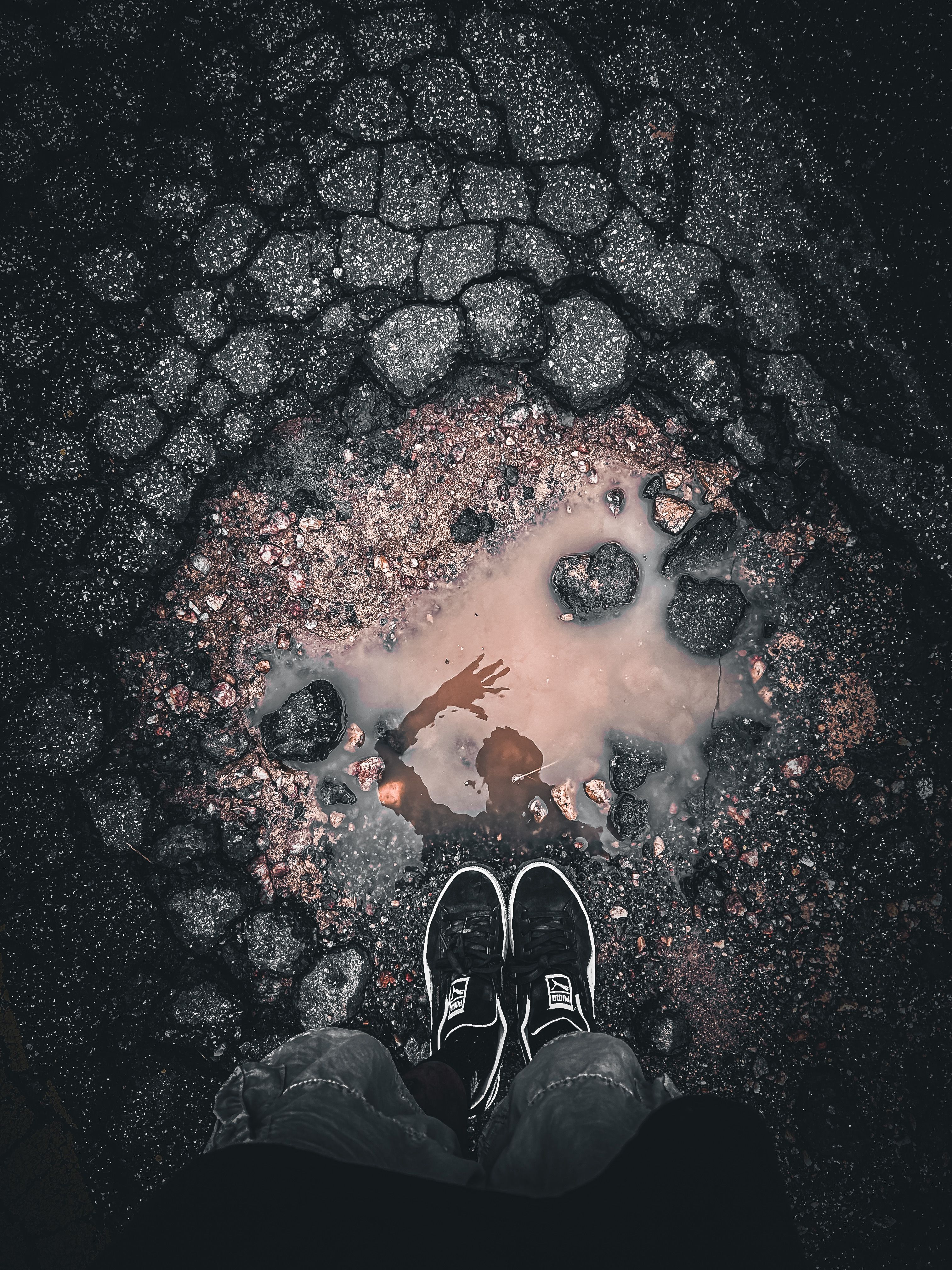 Shoes and Legs of Person Standing over Puddle on Asphalt · Free Stock Photo