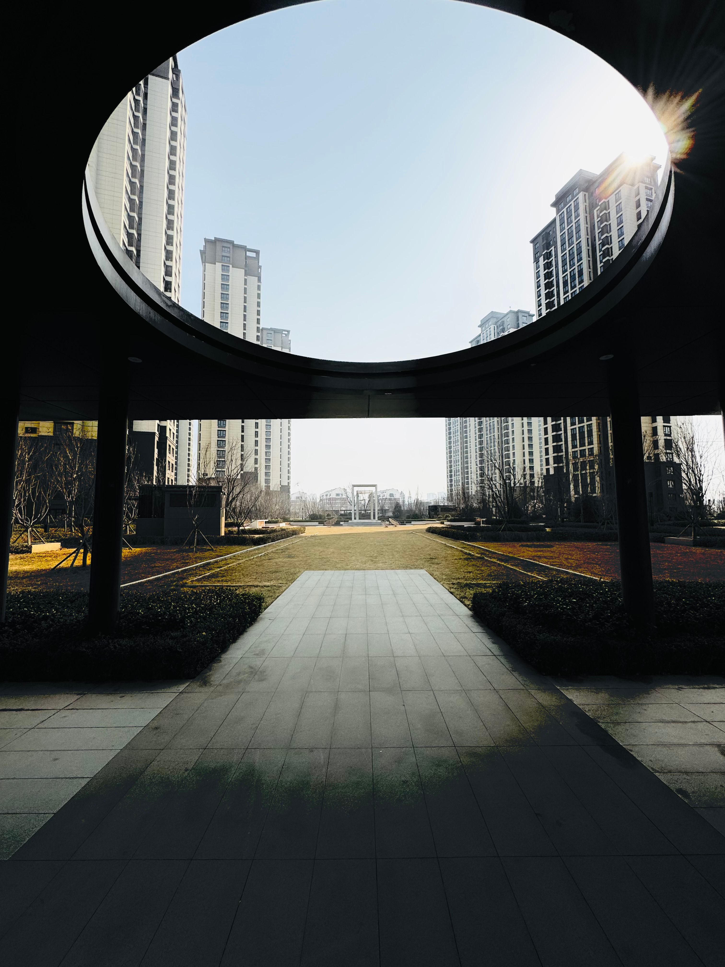 A walkway in front of a building with a circular arch · Free Stock Photo