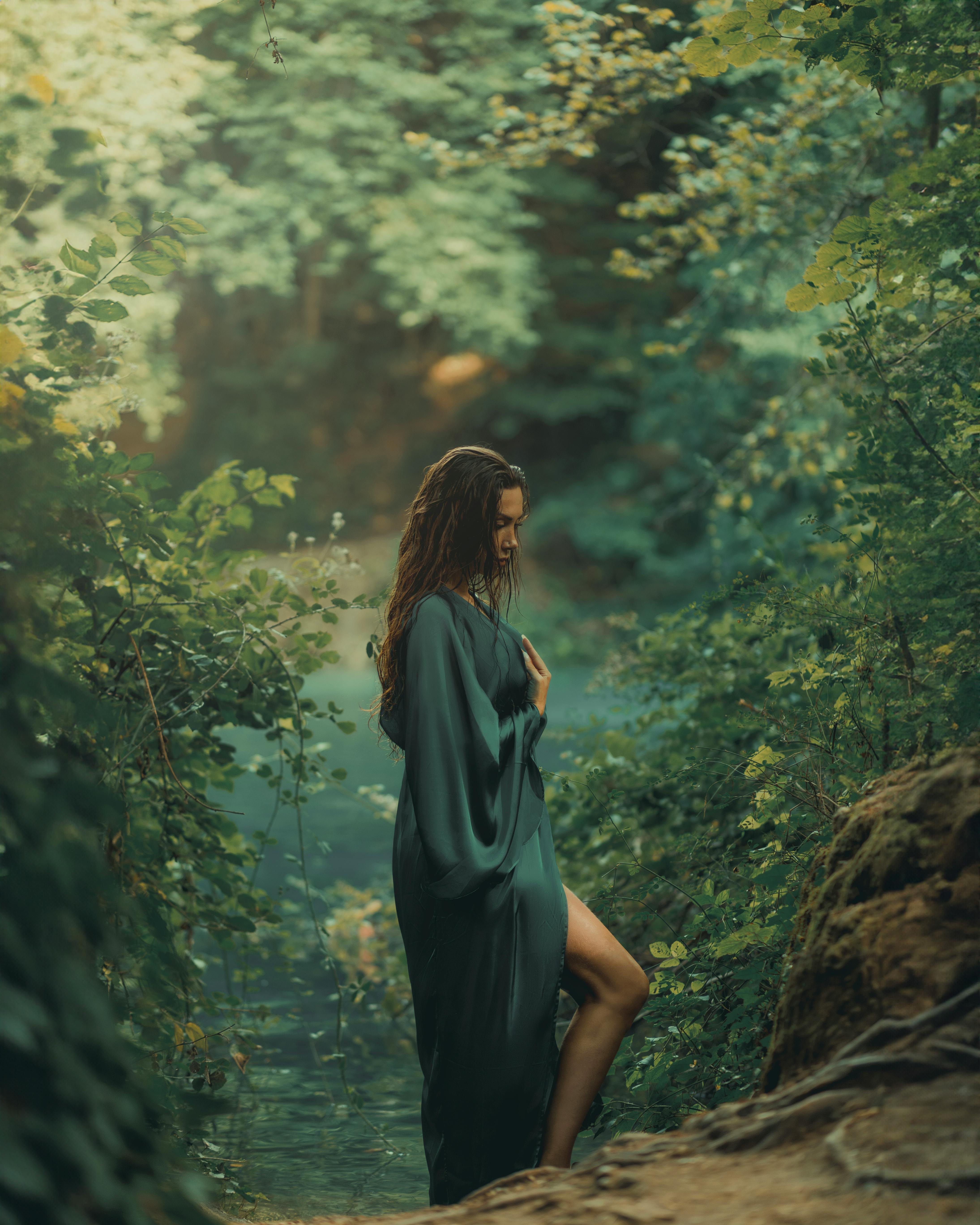 A Woman Wearing a Green Silk Robe Standing near a Body of Water in a ...