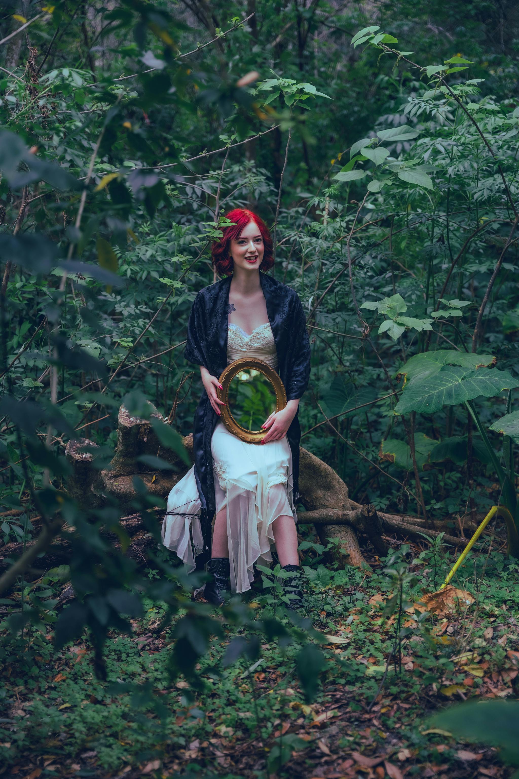 Smiling Classy Woman Holding a Mirror against the Forest Background ...
