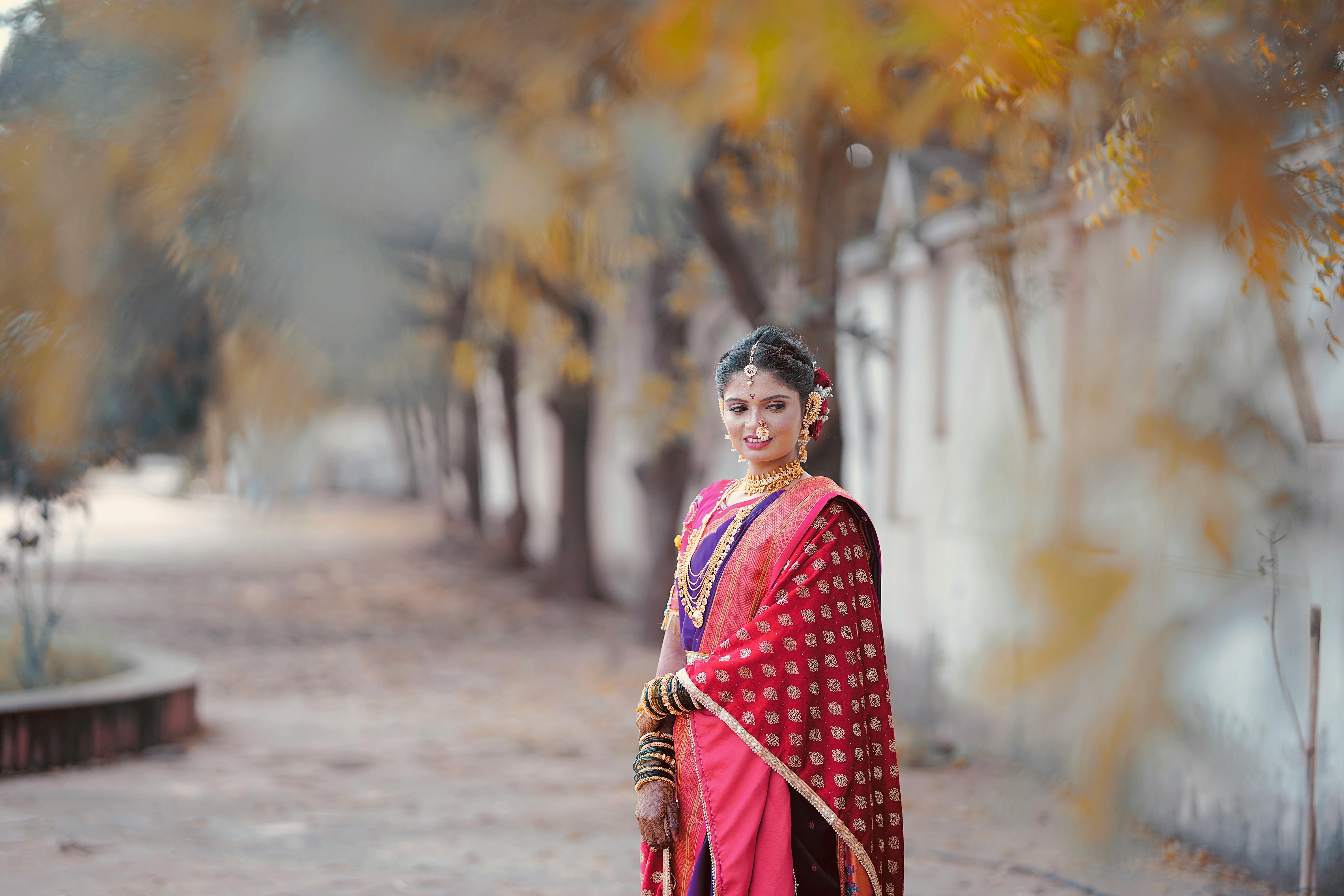 A Woman in a Traditional Sari and Jewelry Standing on a Sidewalk · Free ...