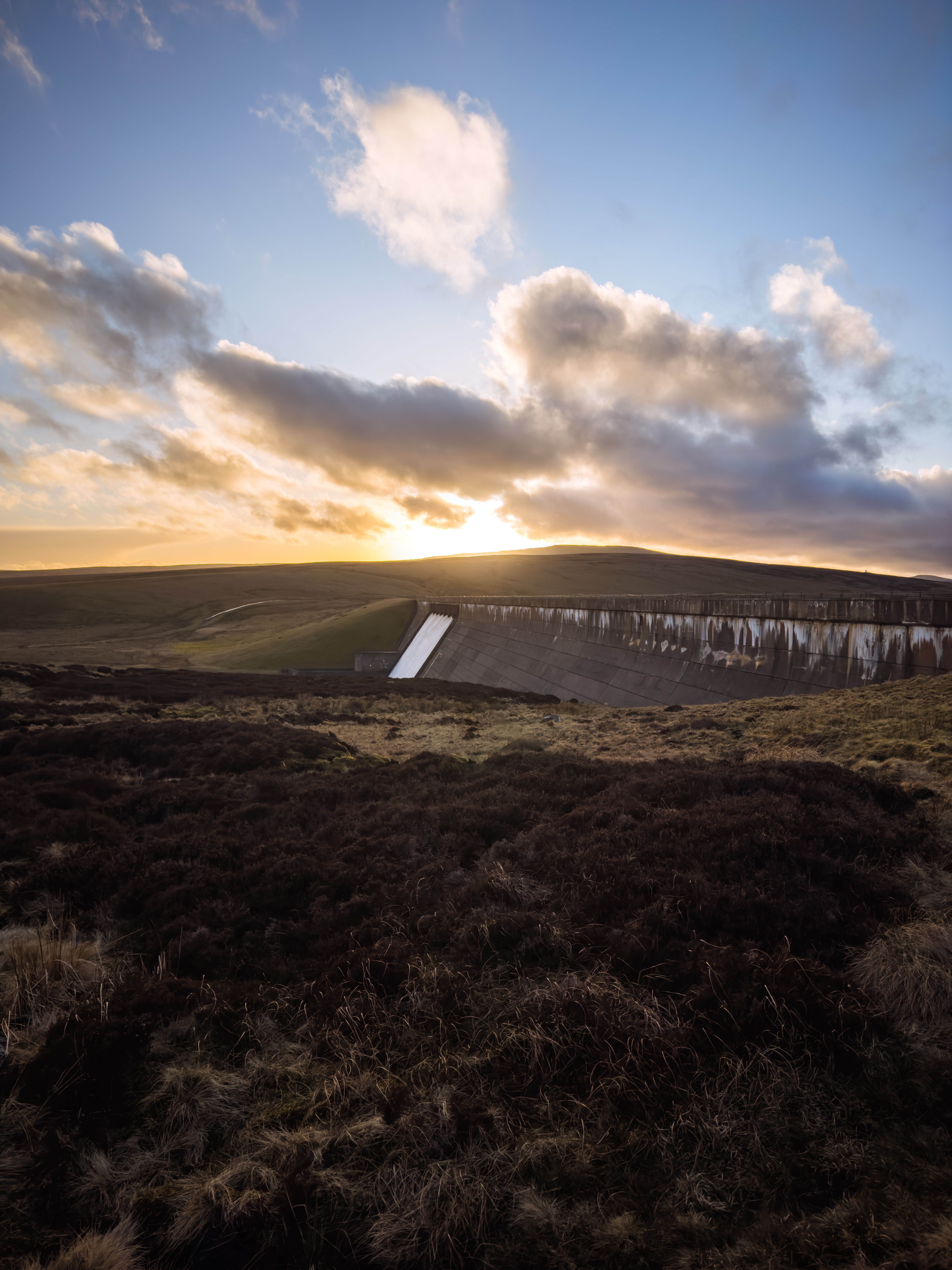 The sun sets over a hill with a water tower · Free Stock Photo