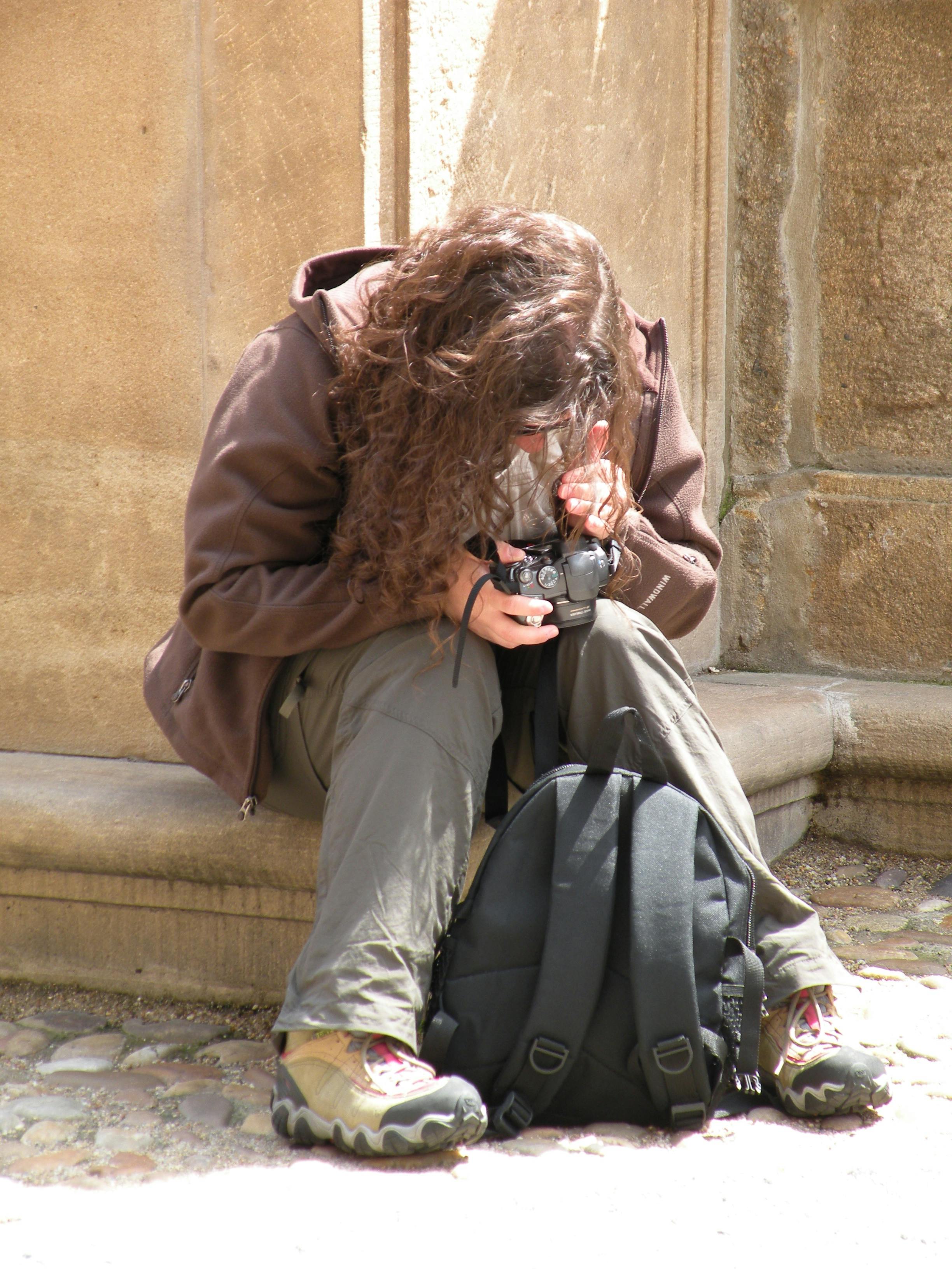 Woman Sitting and Holding Digital Camera · Free Stock Photo