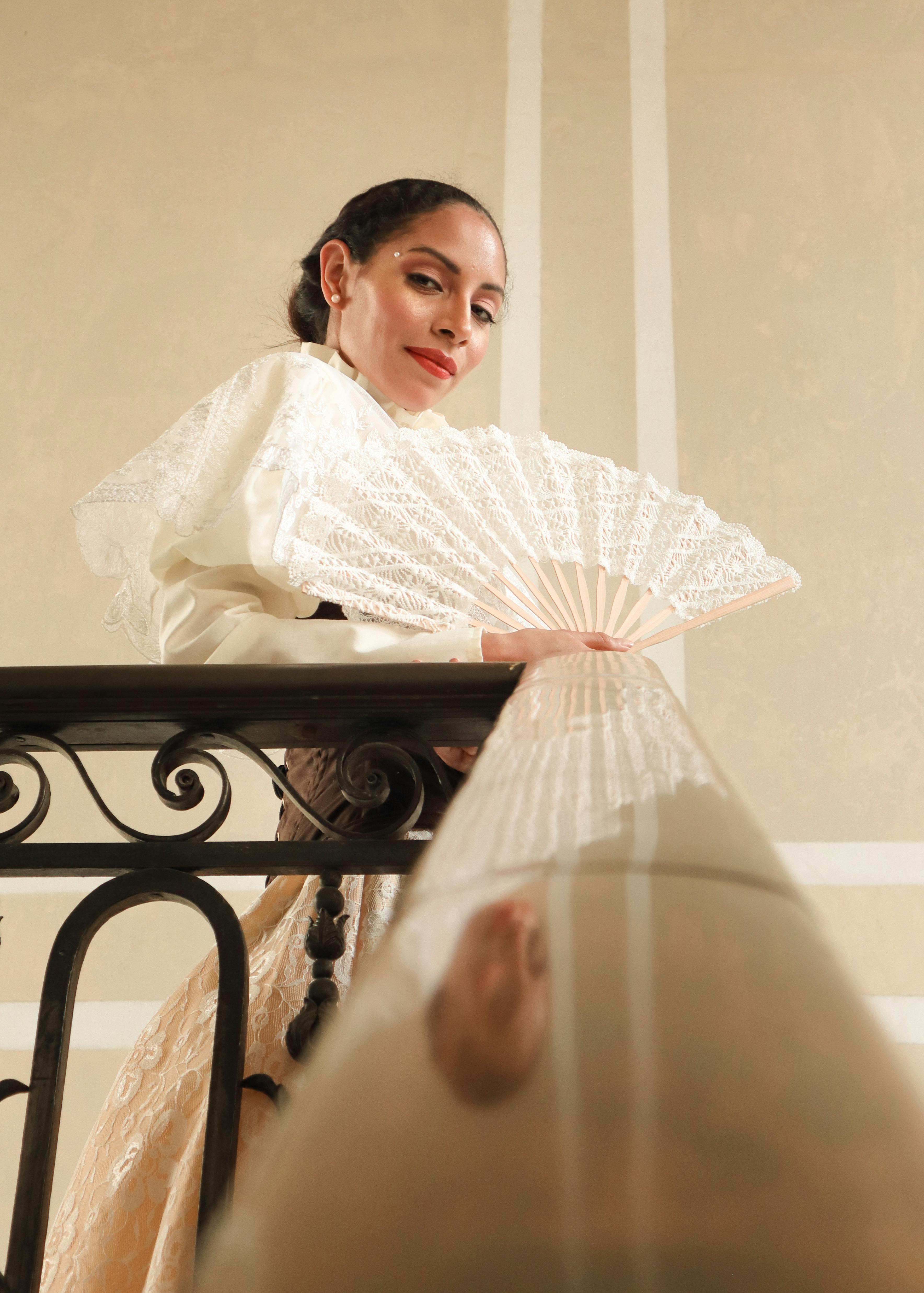 Brunette Woman in White Dress with Fancy Hand Fan Posing by Railing ...