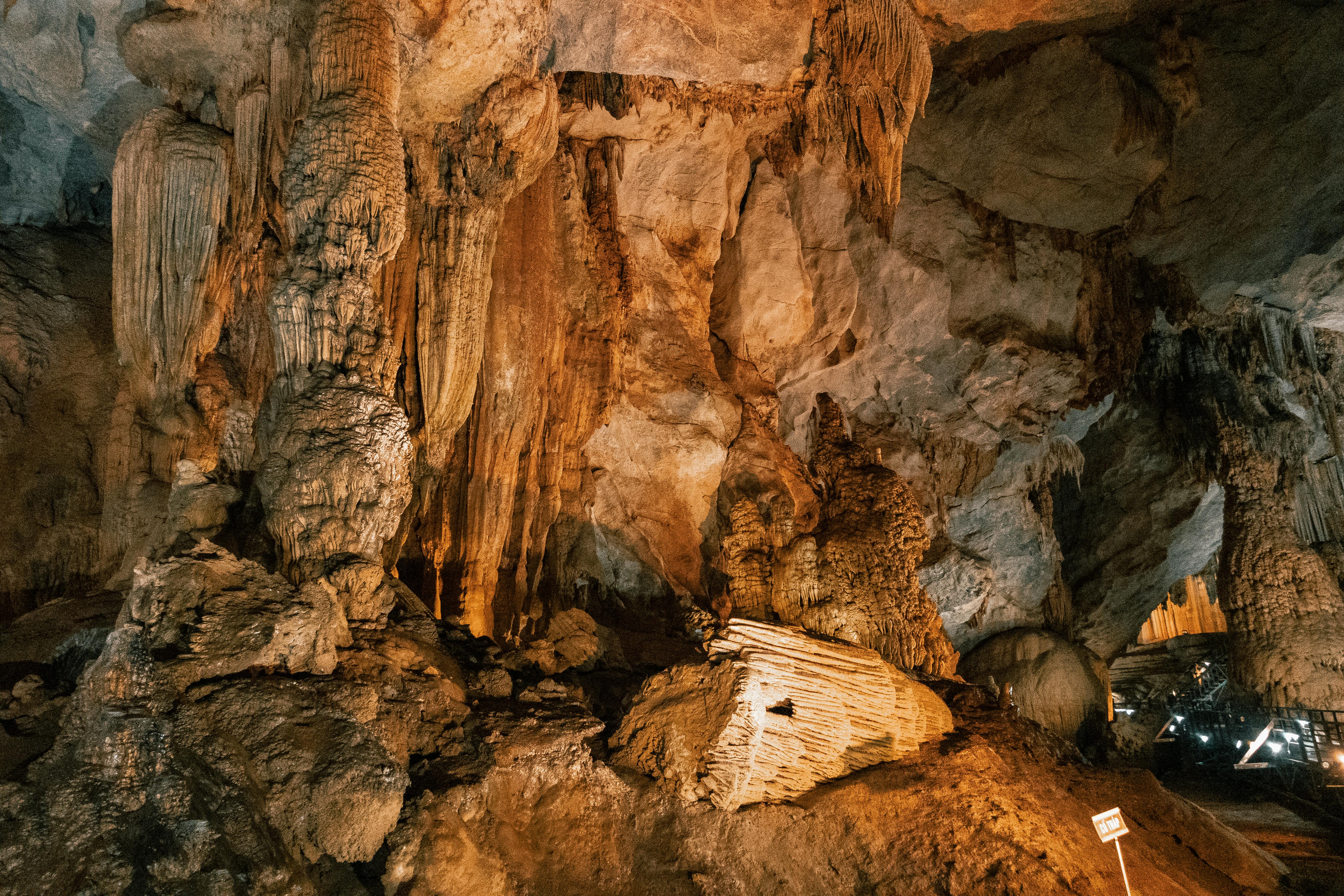 The cave is filled with large rocks and stalagmites · Free Stock Photo
