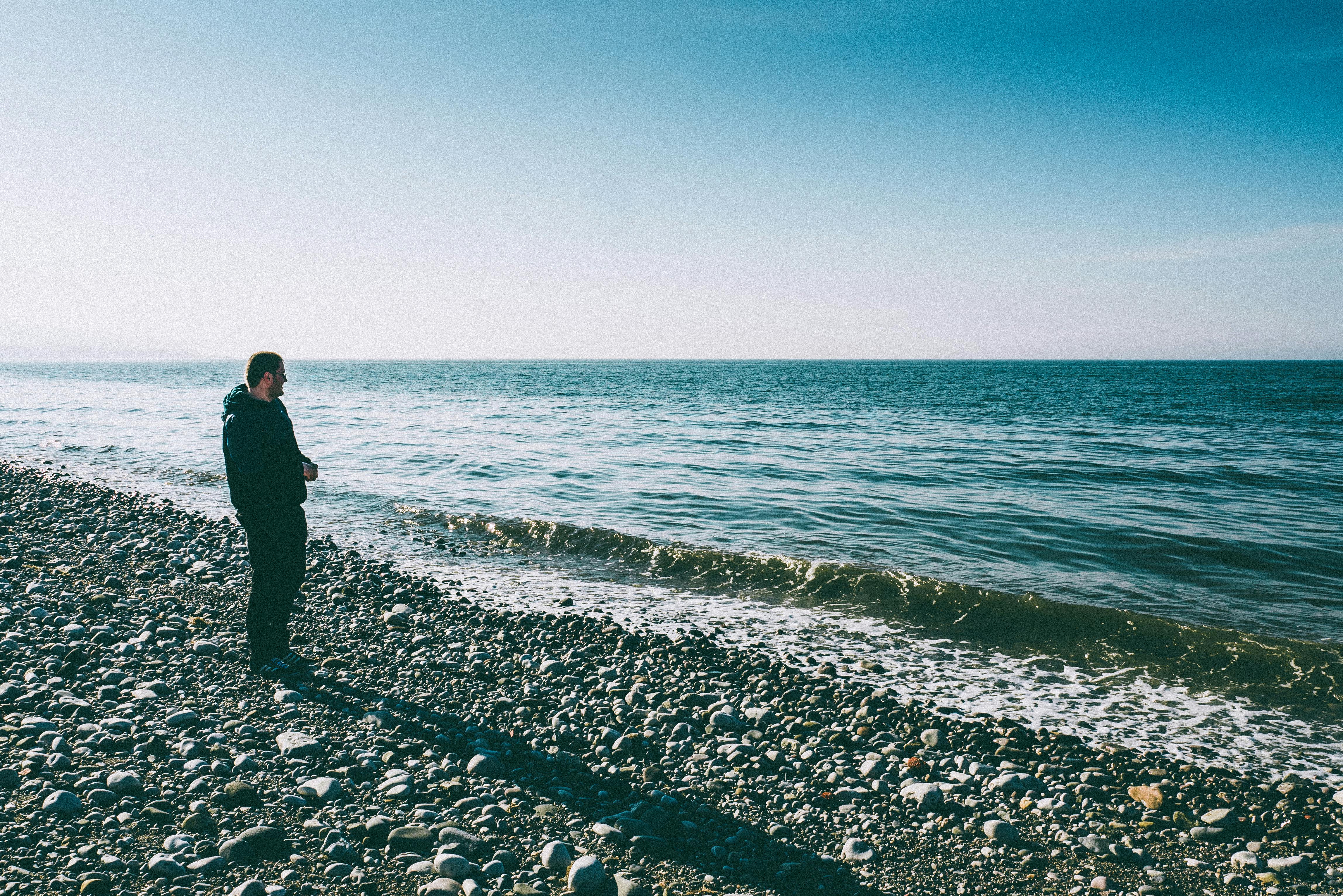 Man Standing Beside Shore · Free Stock Photo
