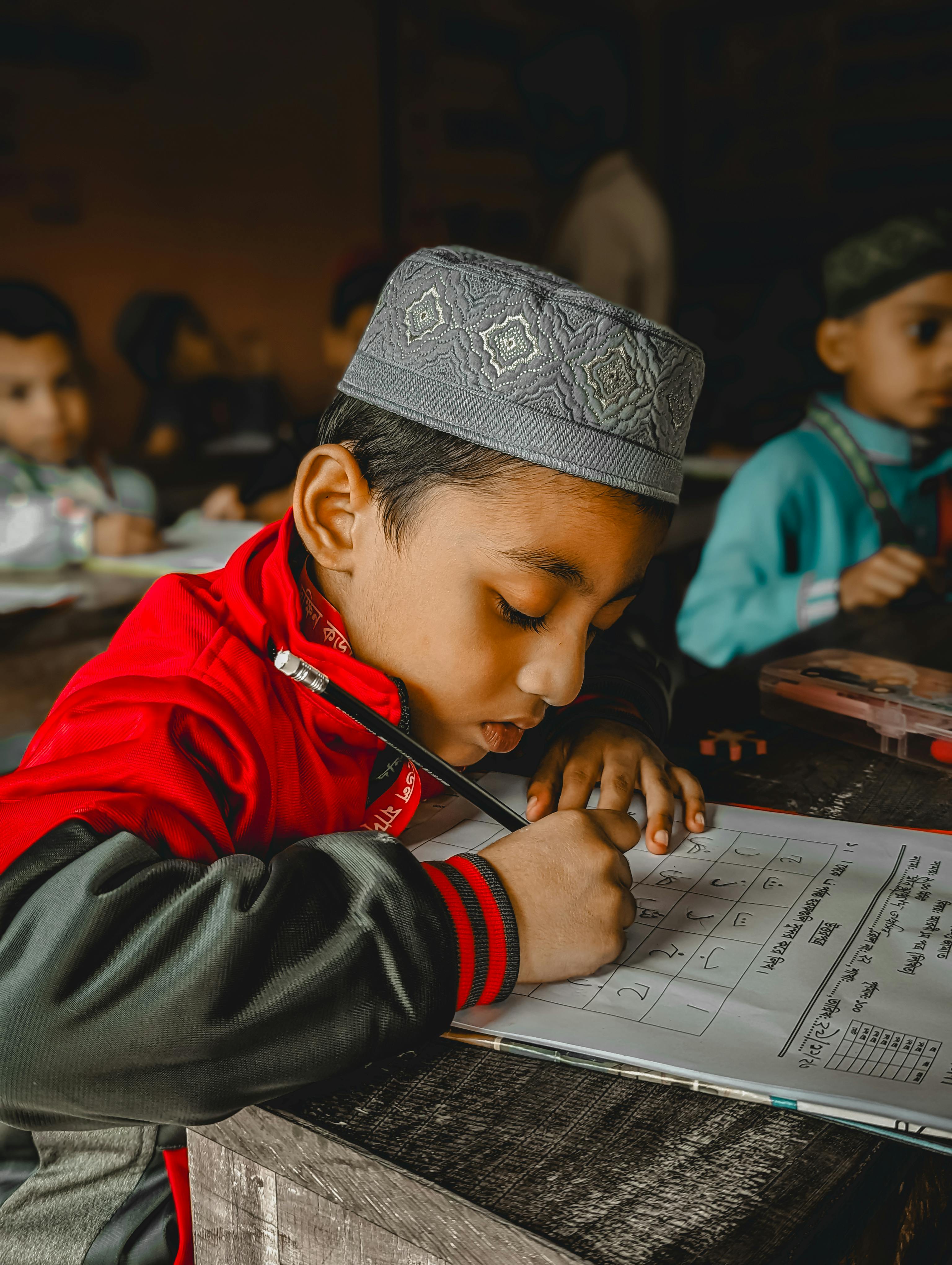 A Schoolboy Wearing a Traditional Cap Sitting at the Desk in a ...
