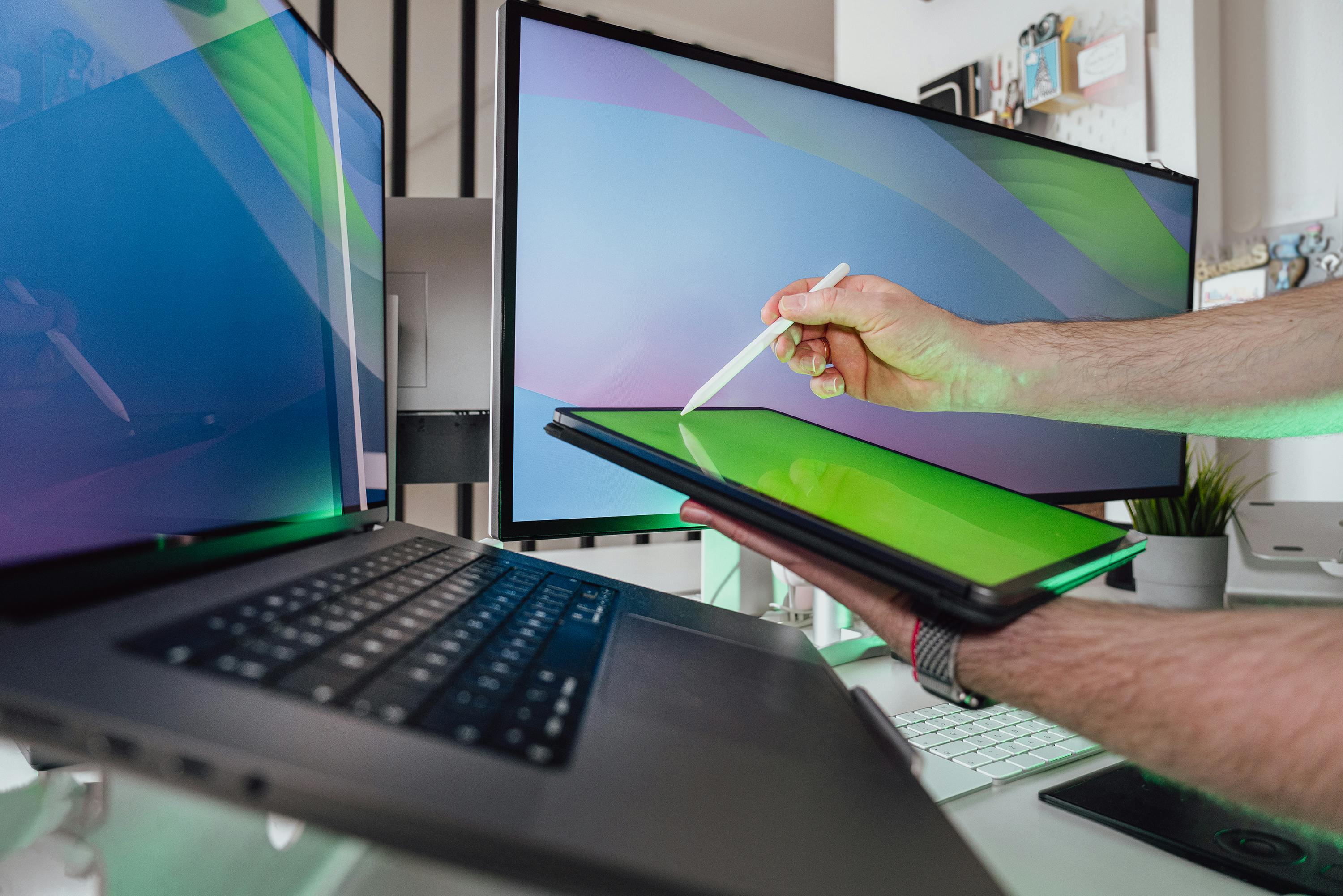 Men Hands Holding Tablet over Laptop and Monitor · Free Stock Photo