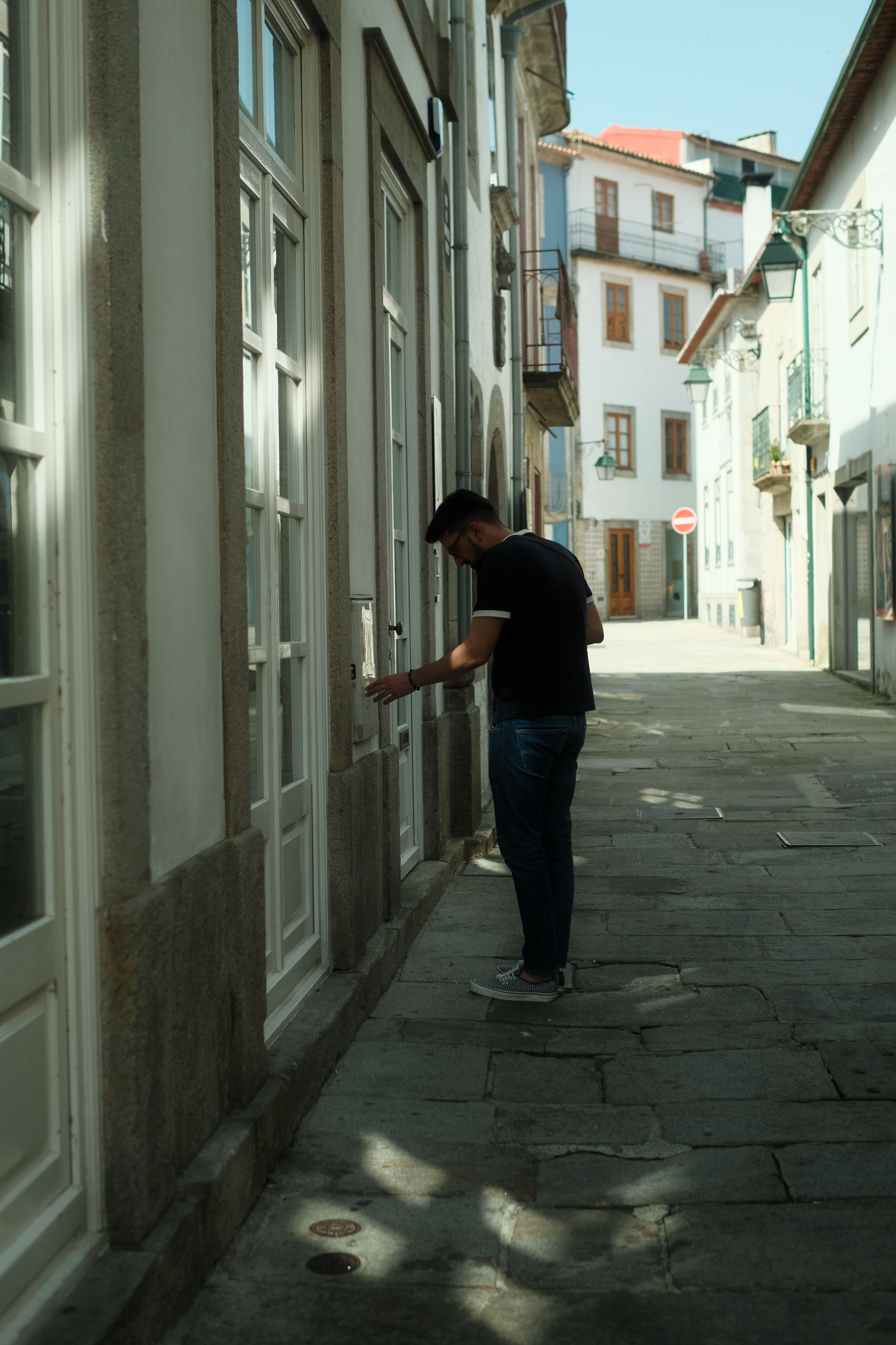 Man Standing near Building Wall in Alley in Town · Free Stock Photo