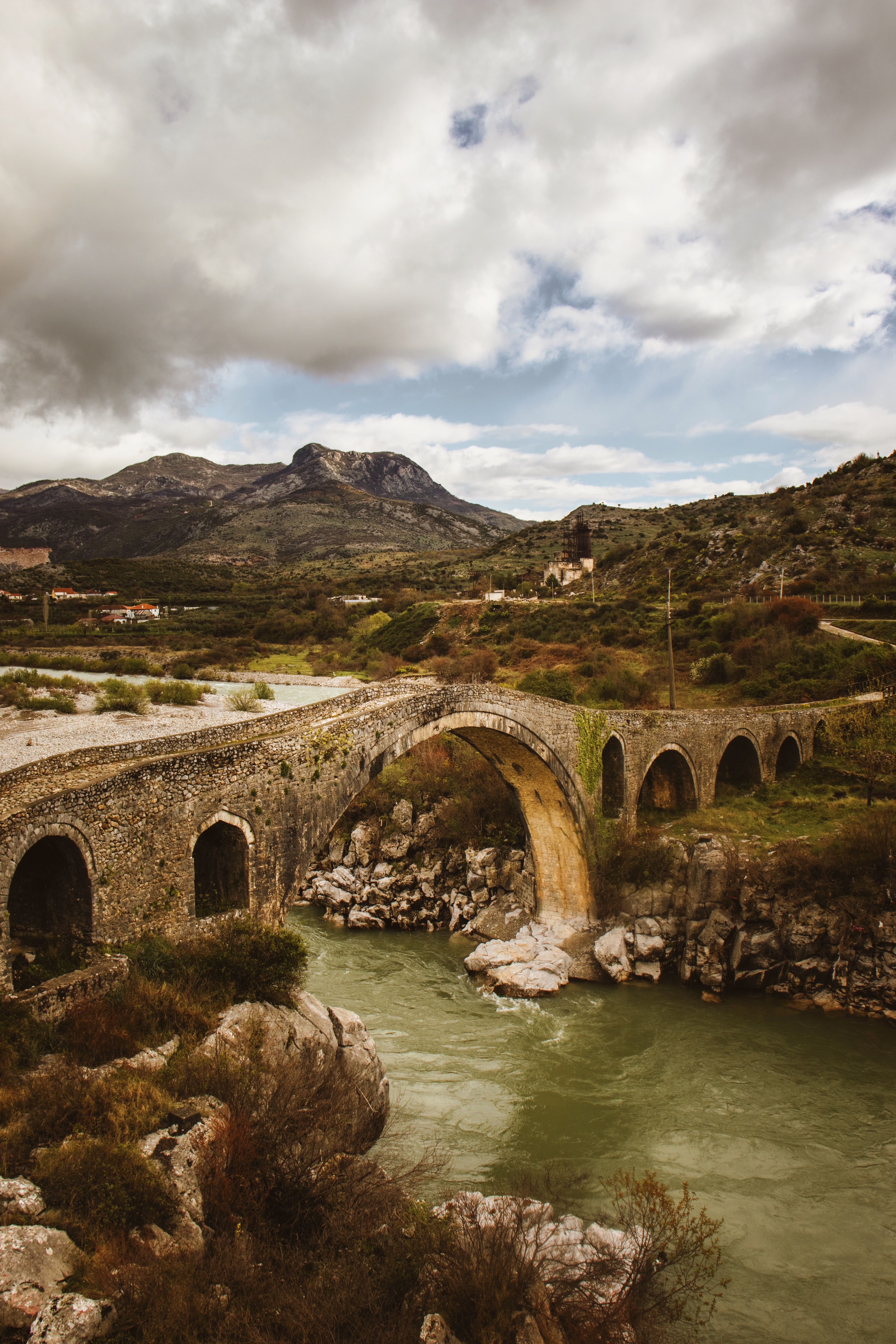 An old stone bridge over a river in the mountains · Free Stock Photo