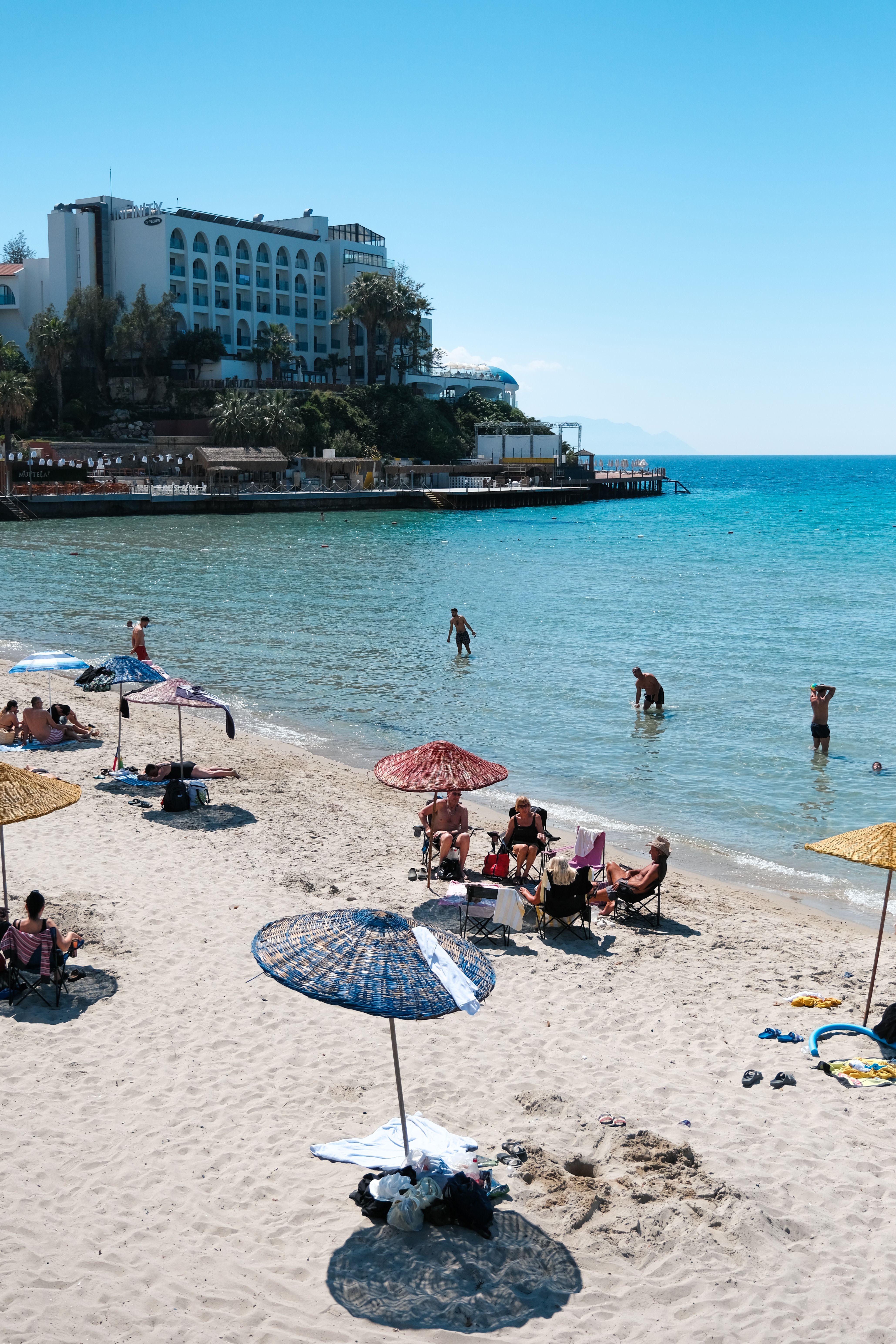 Tranquil beach scene with sunbathers and a waterfront hotel · Free ...