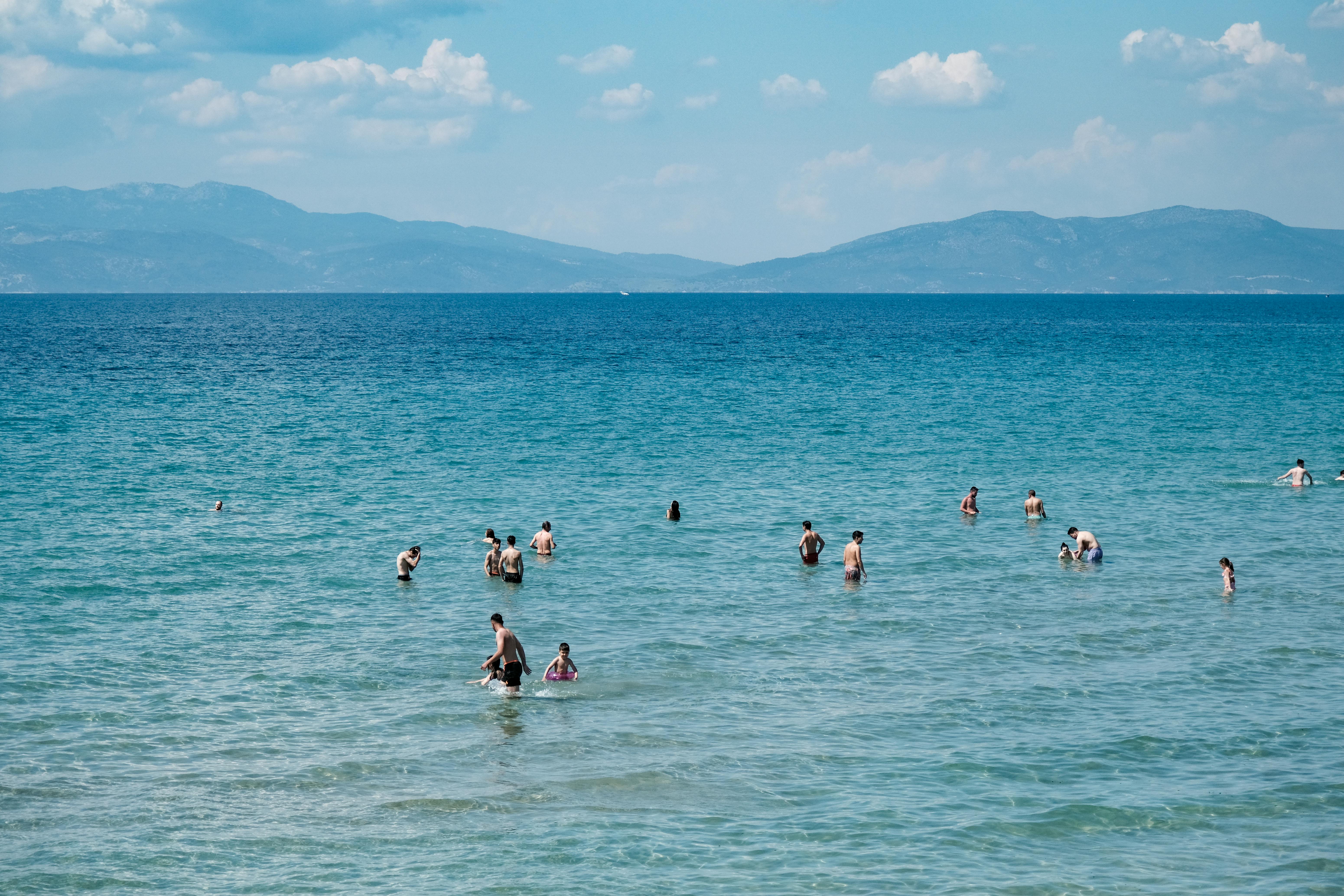 Beachgoers enjoying the clear turquoise waters on a sunny day · Free ...