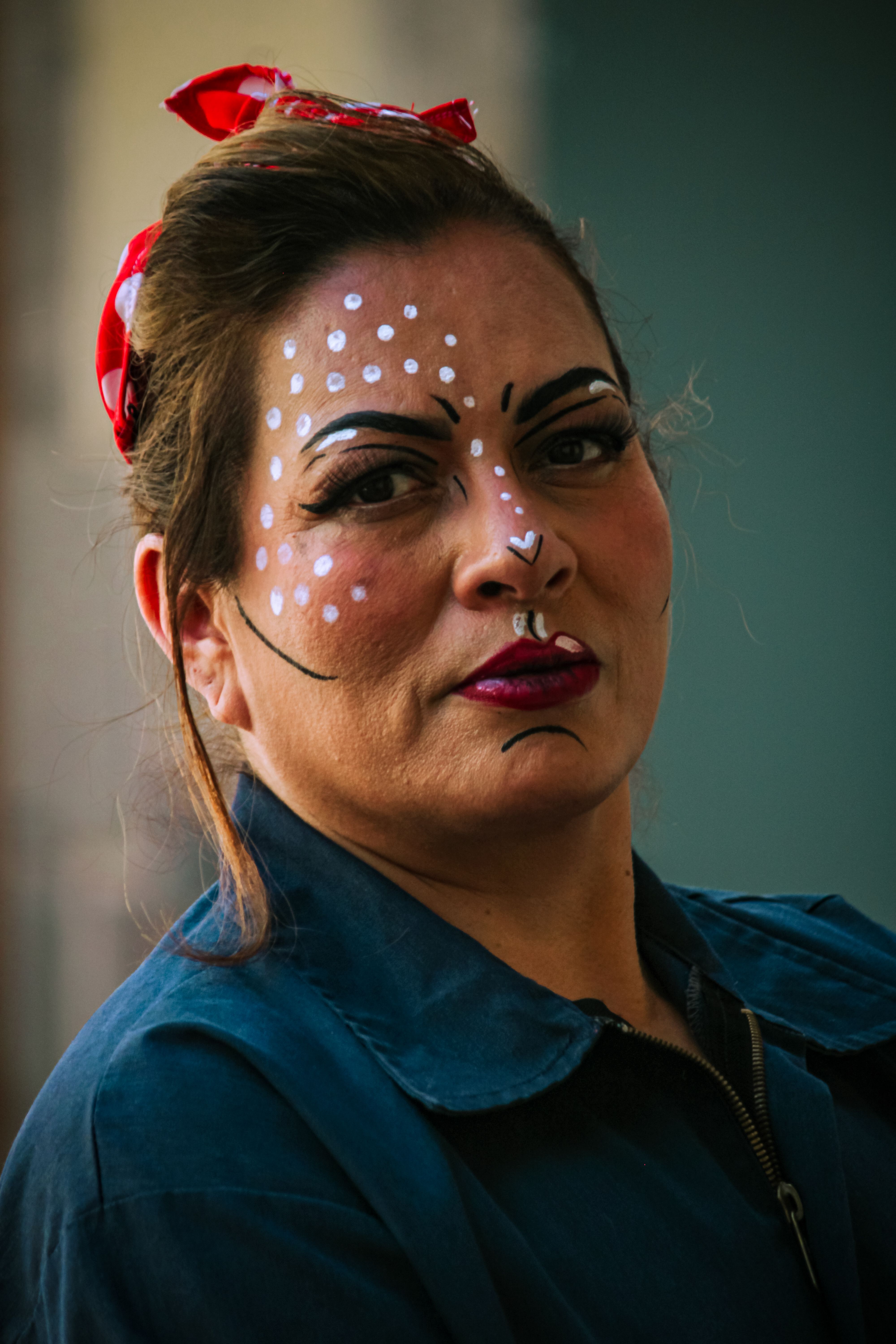A woman with face paint and a red dot on her nose · Free Stock Photo