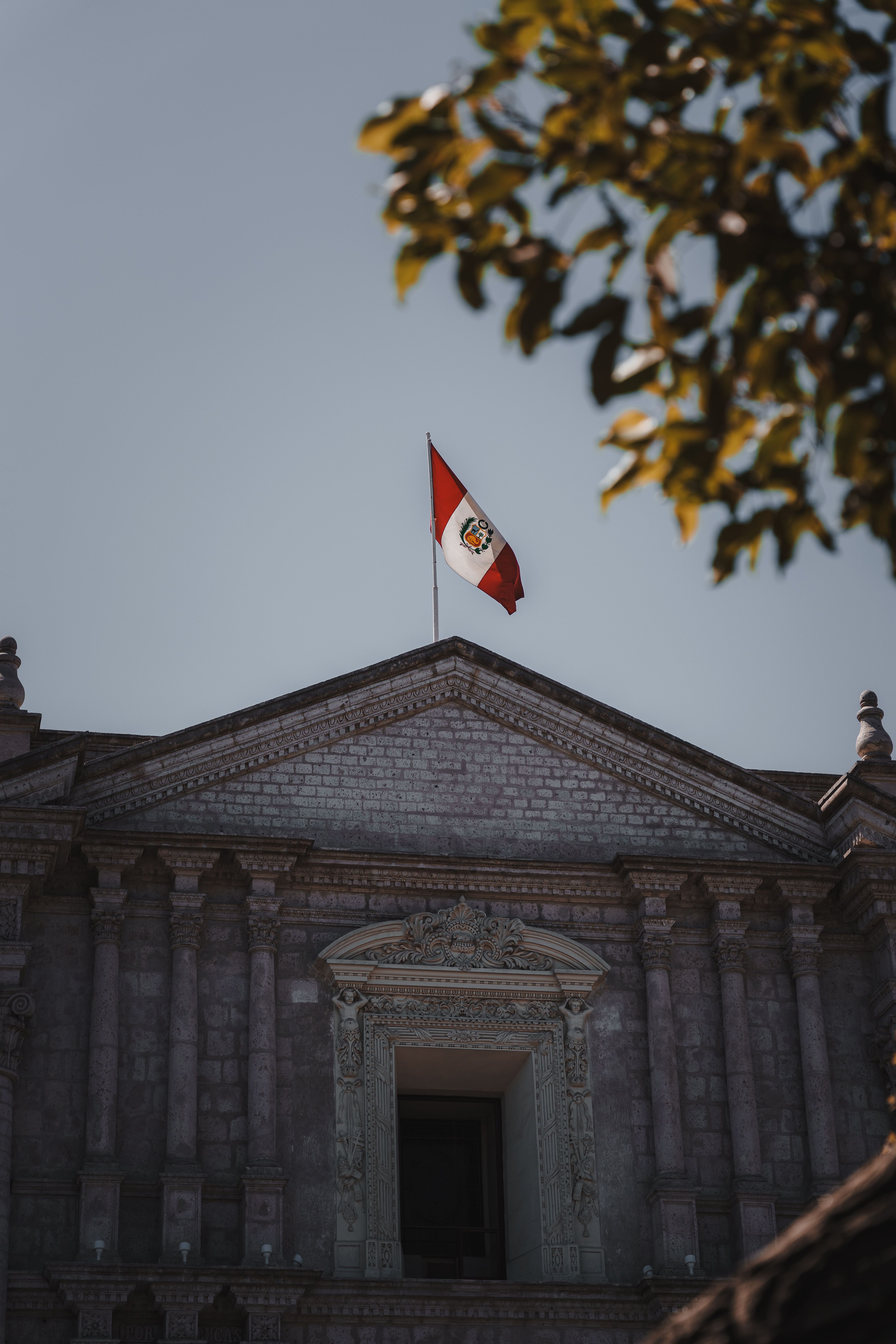Facade of a Building with Architectural Details and a Flag of Peru ...