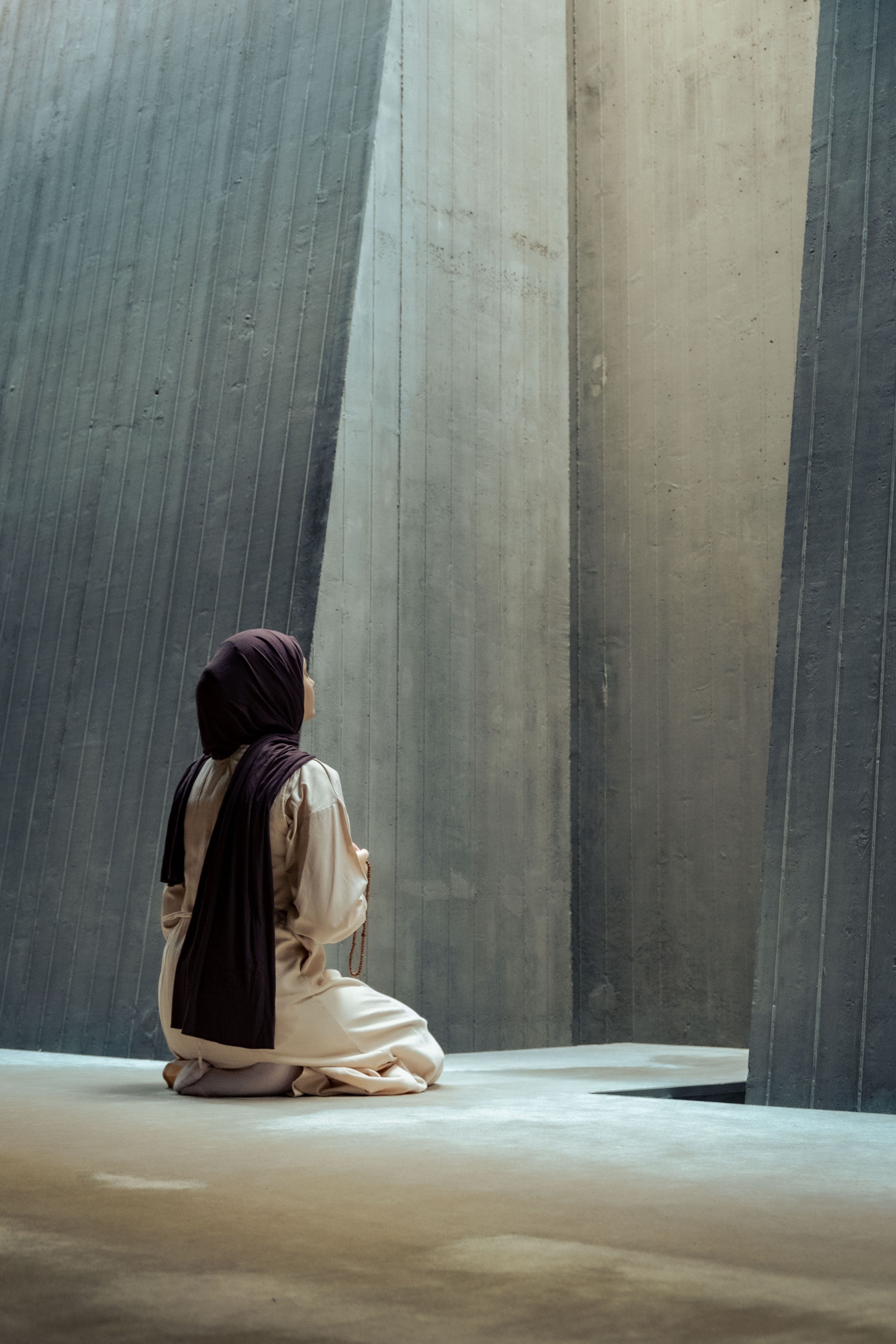 Back View of Woman Kneeling by Wall at Mosque · Free Stock Photo