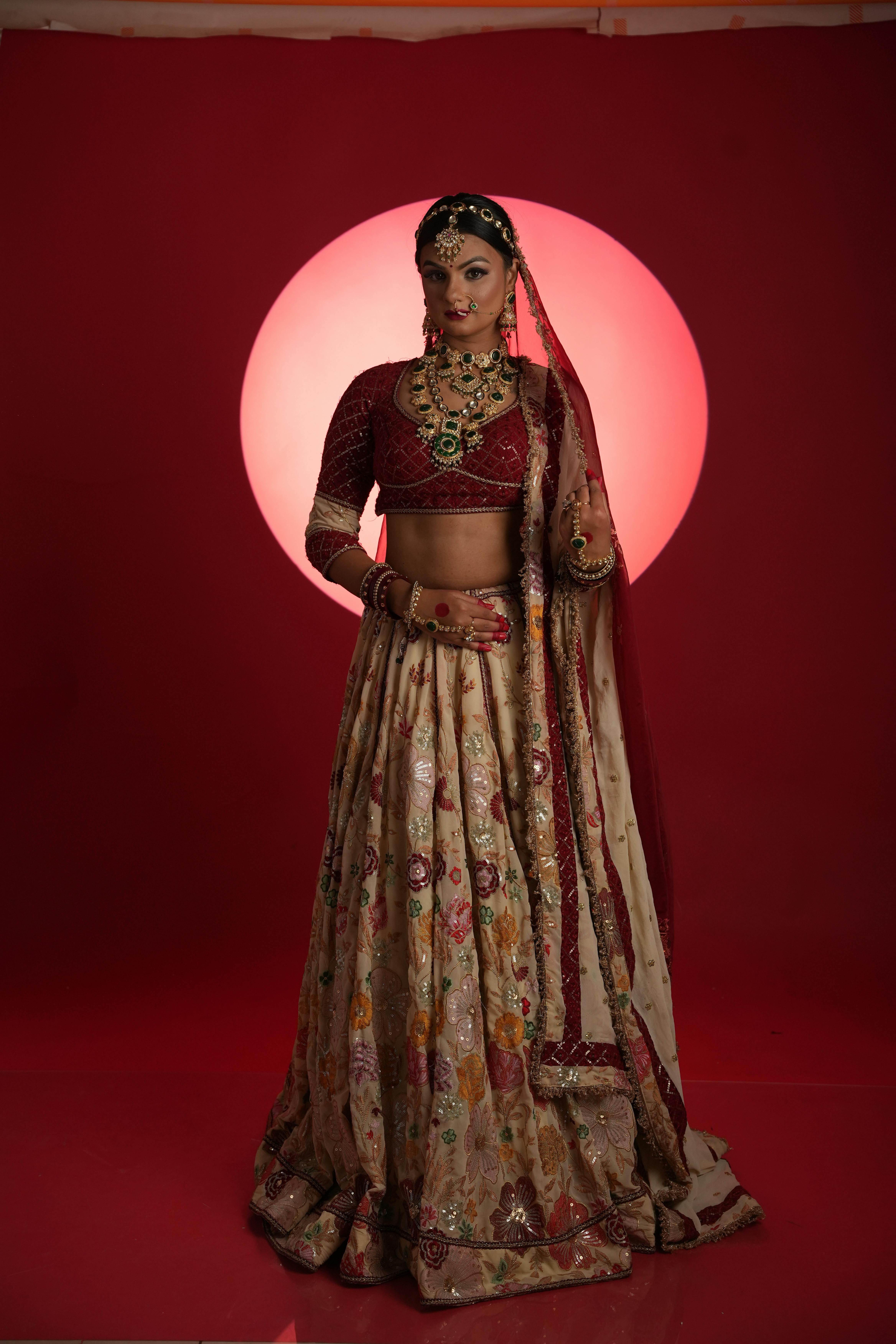 A woman in a red and gold lehenga · Free Stock Photo
