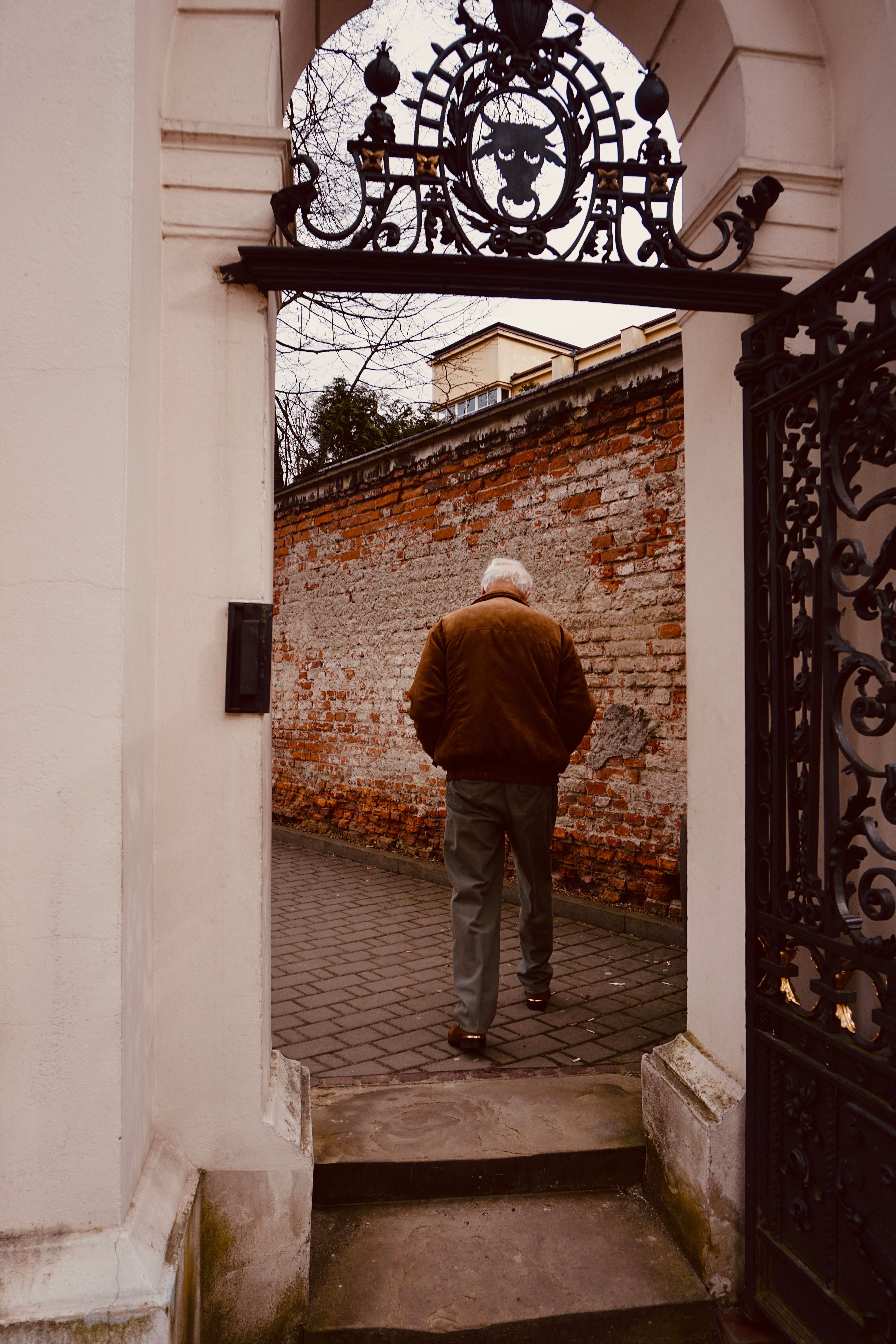 Elderly Man Walks Out of the Gate · Free Stock Photo