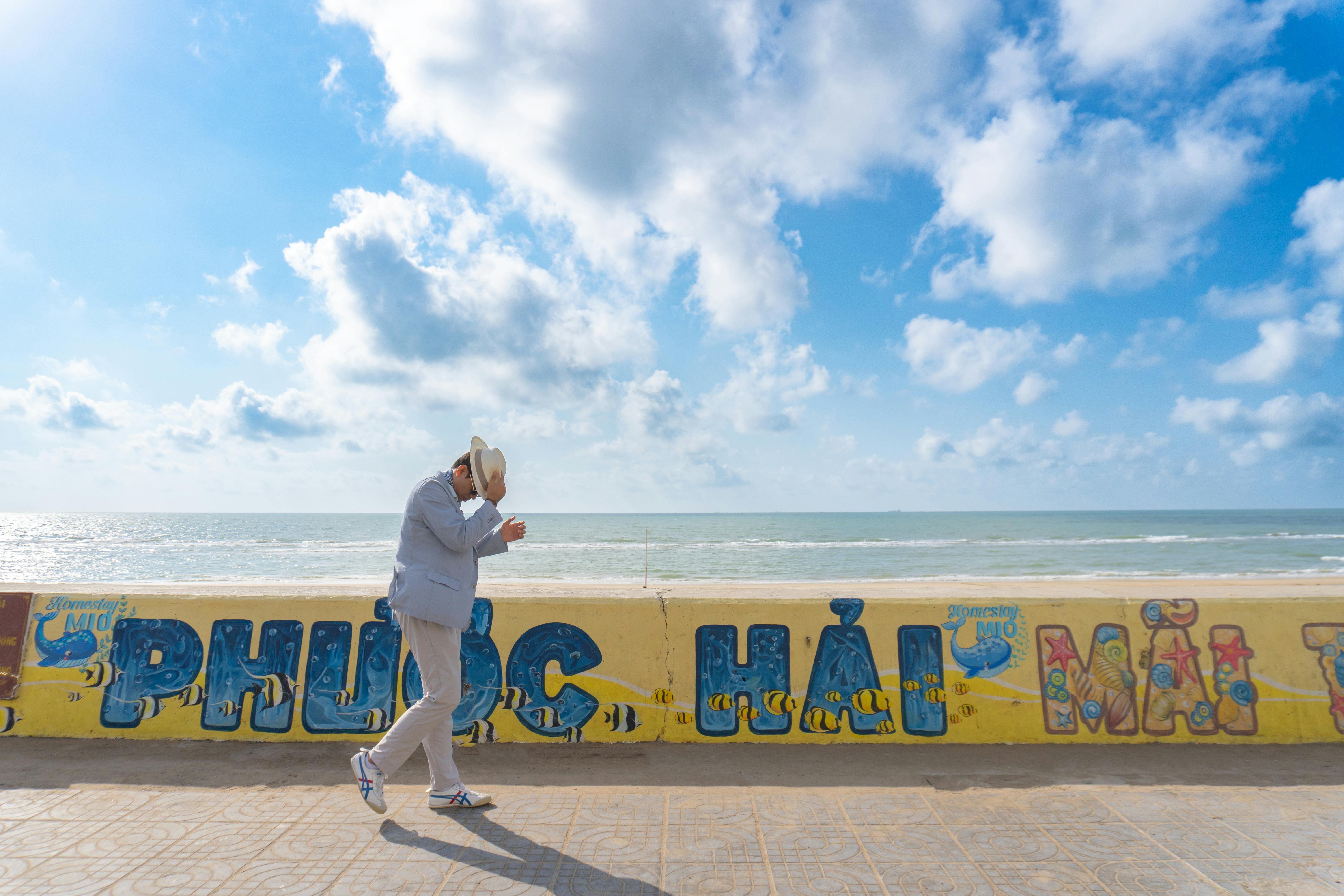 A Man Covering Face With a Panama Hat Walking on a Promenade at the Phuoc Hai Beach, Vietnam ...