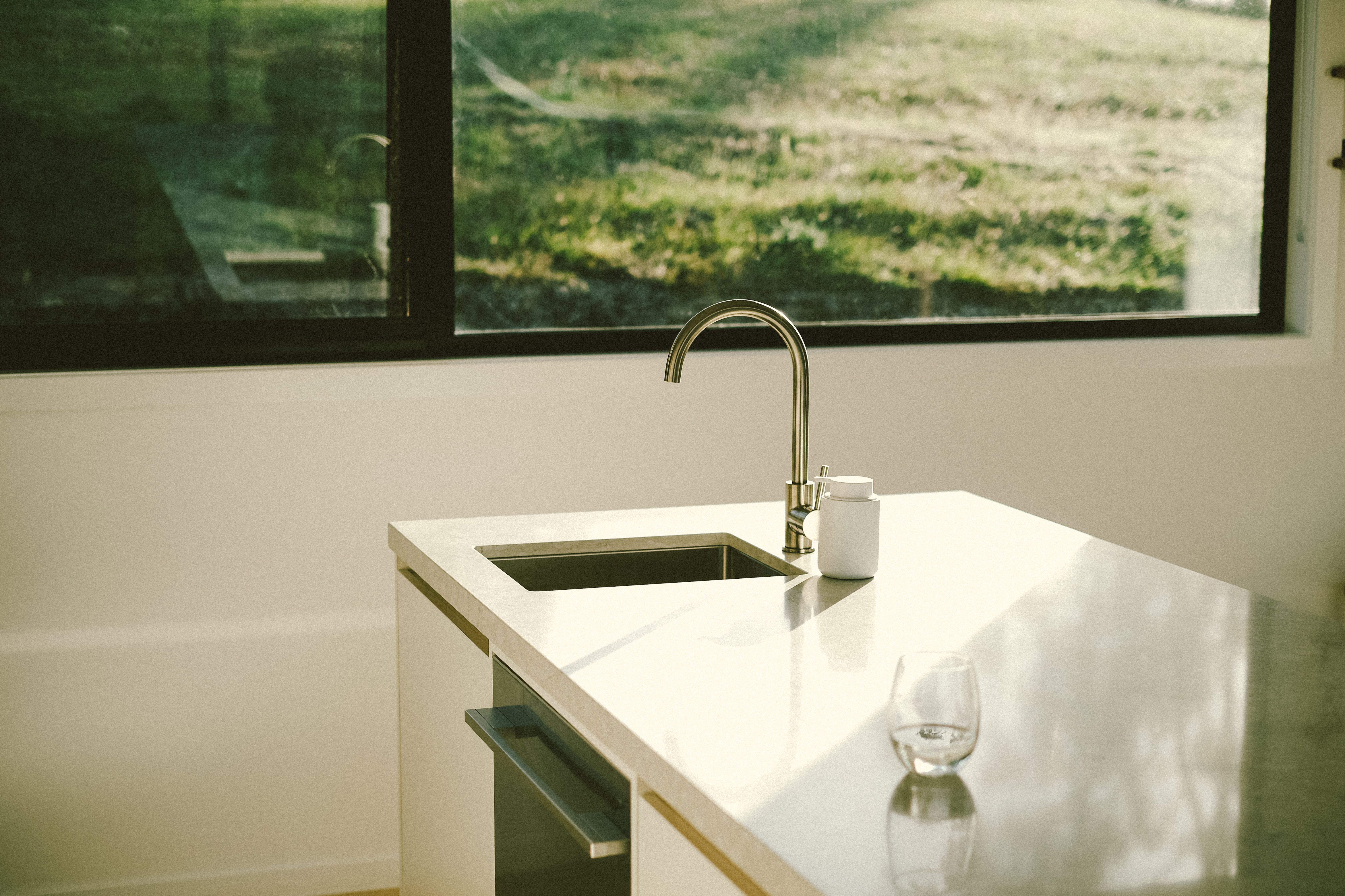 Faucet in a Modern Kitchen Interior, and Green Grass Behind the Window ...