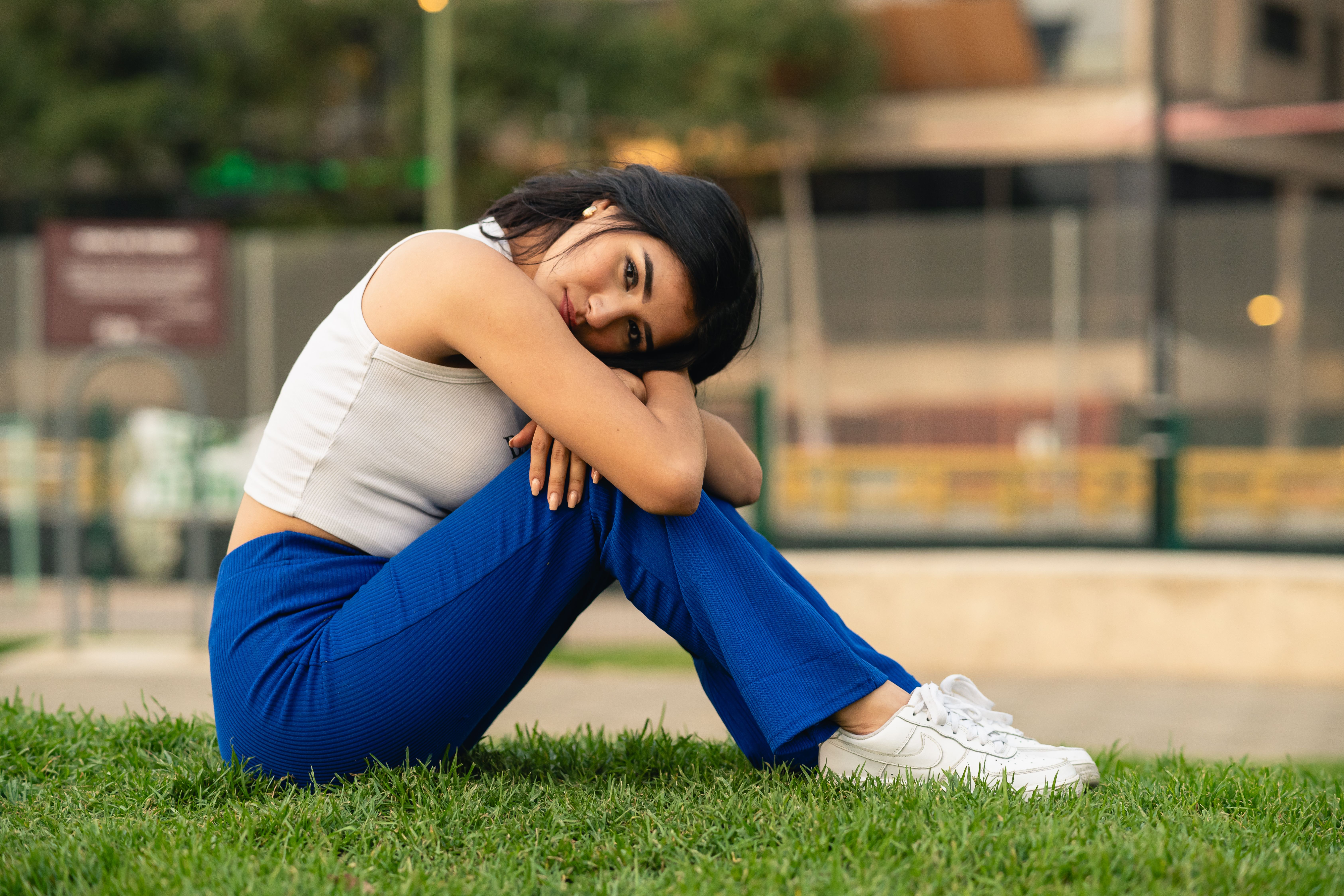 Photo of a Brunette Wearing Blue Trousers, Sitting on the Green Grass ...
