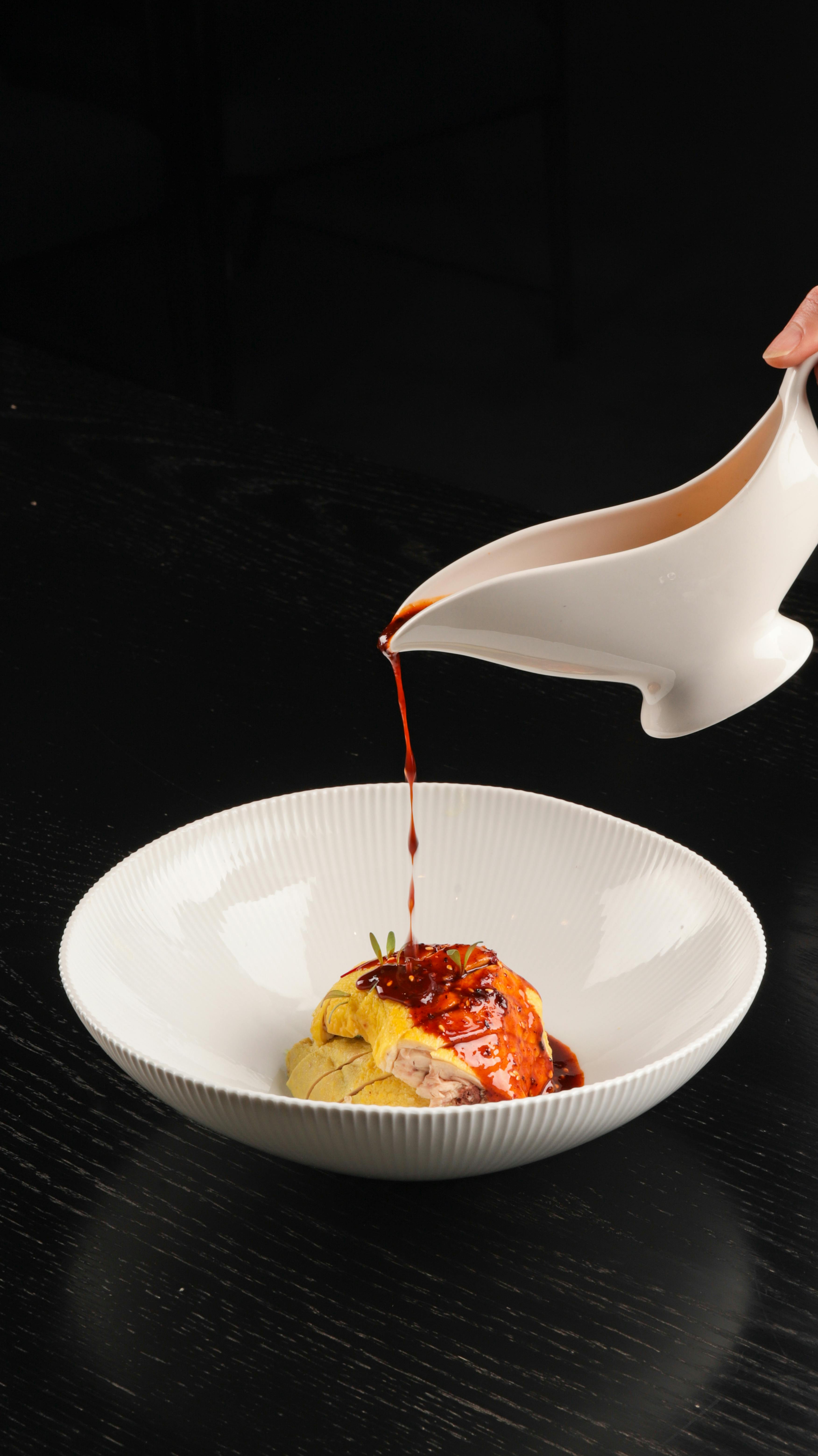 Pouring Sauce on Meal in Bowl · Free Stock Photo
