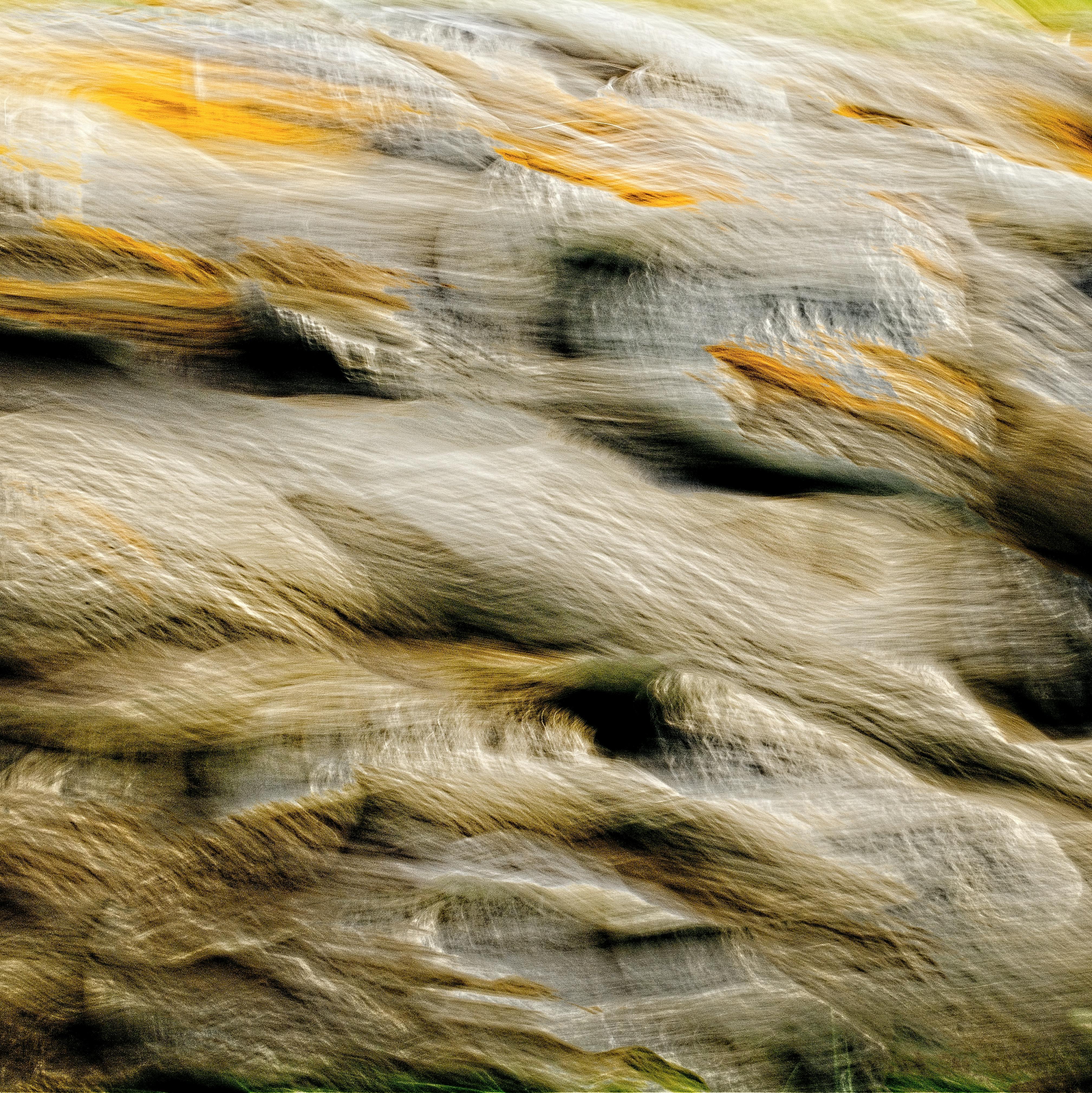 A blurry photograph of rocks and grass · Free Stock Photo