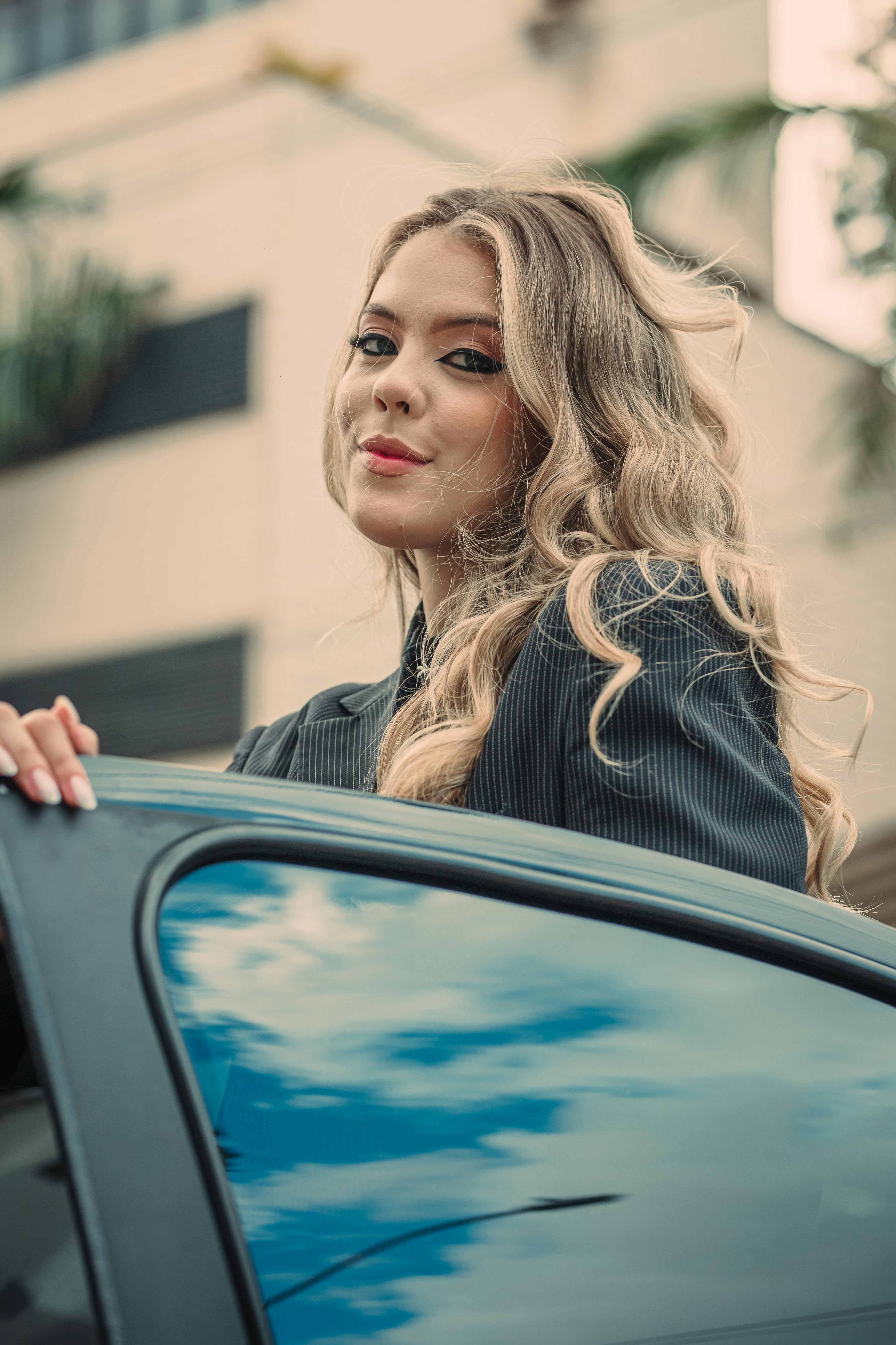Portrait of Blonde Woman behind Car Door · Free Stock Photo