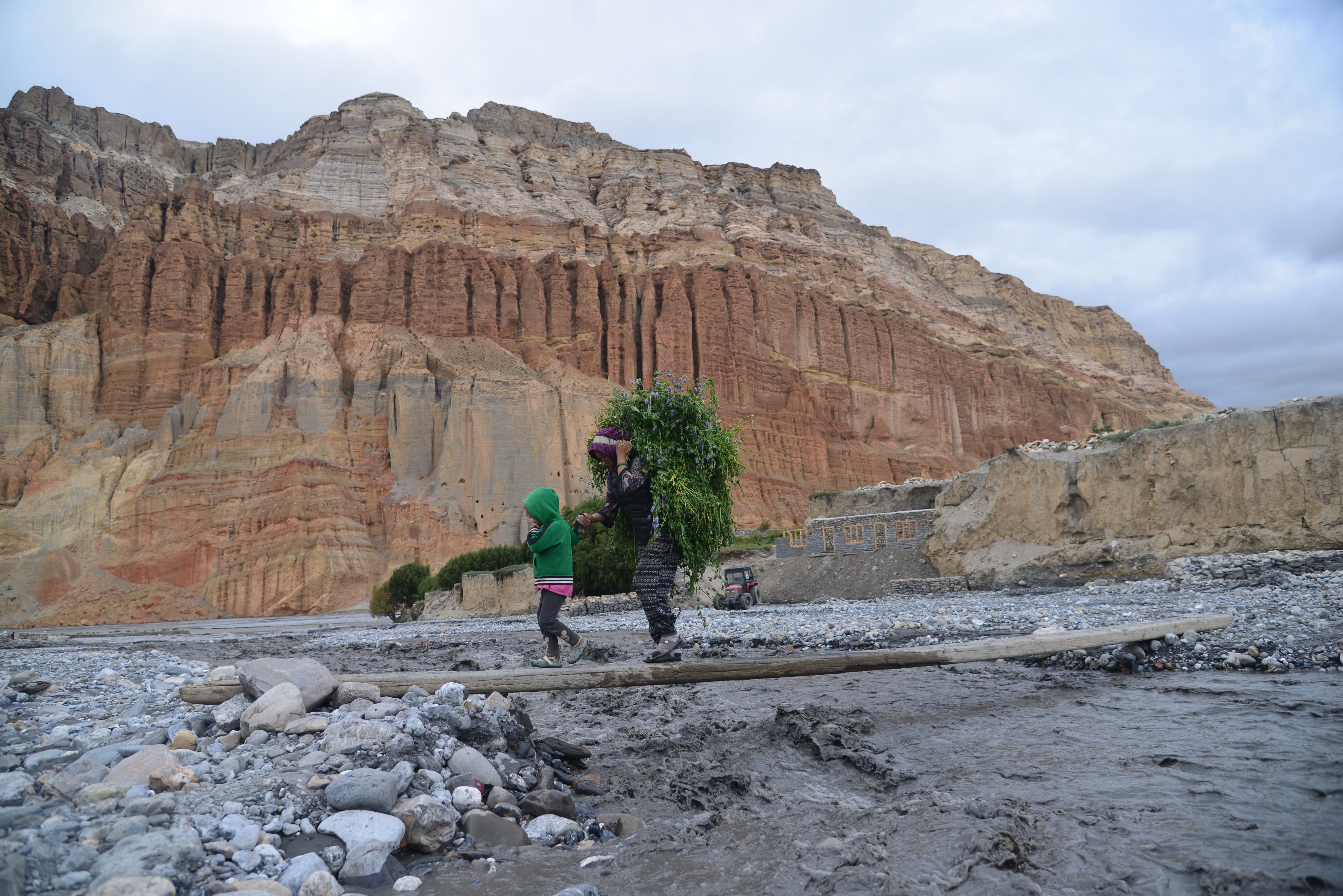 A Child and a Woman Walking in the Valley near a Large Cliff in ...