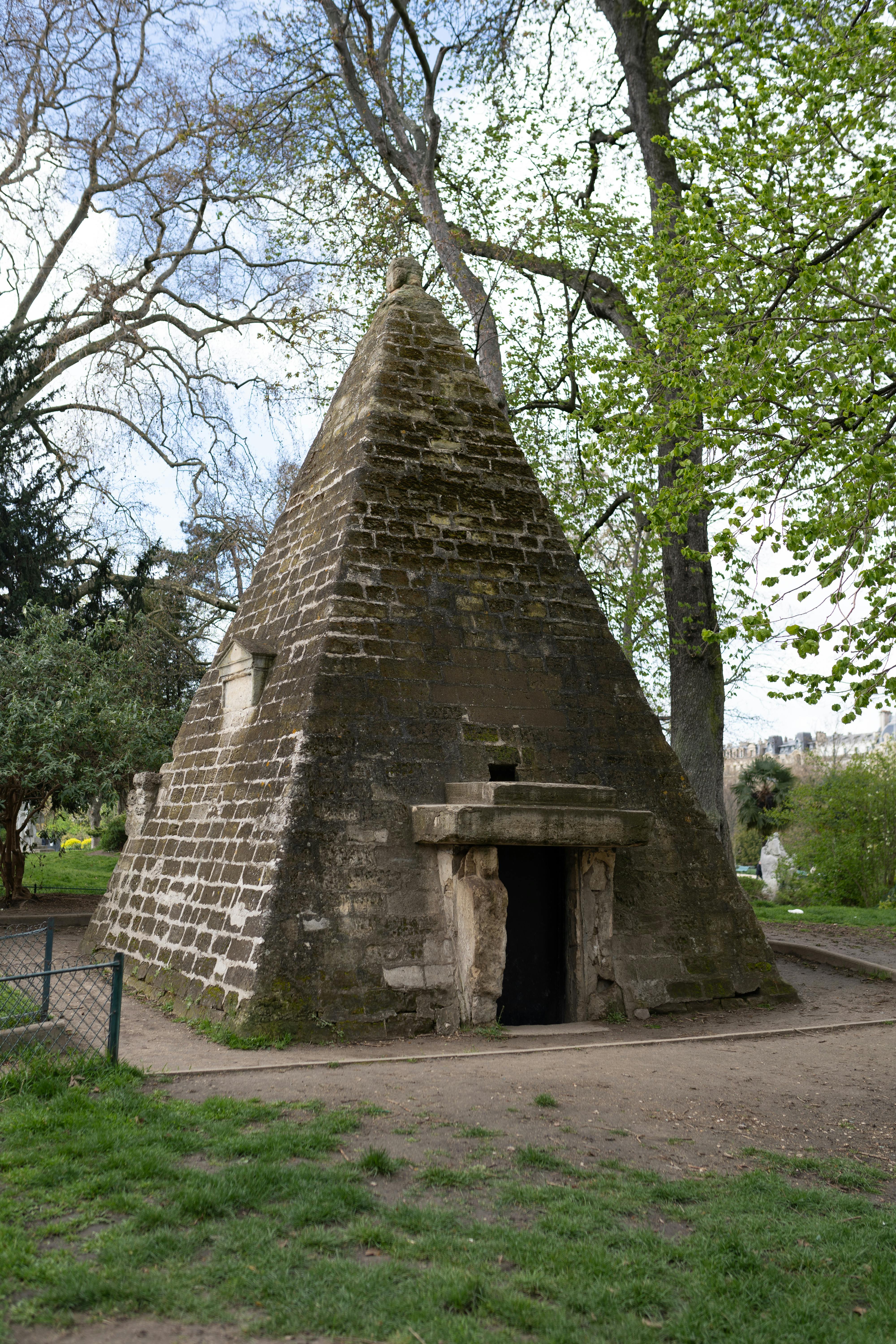 A small pyramid shaped building in a park · Free Stock Photo