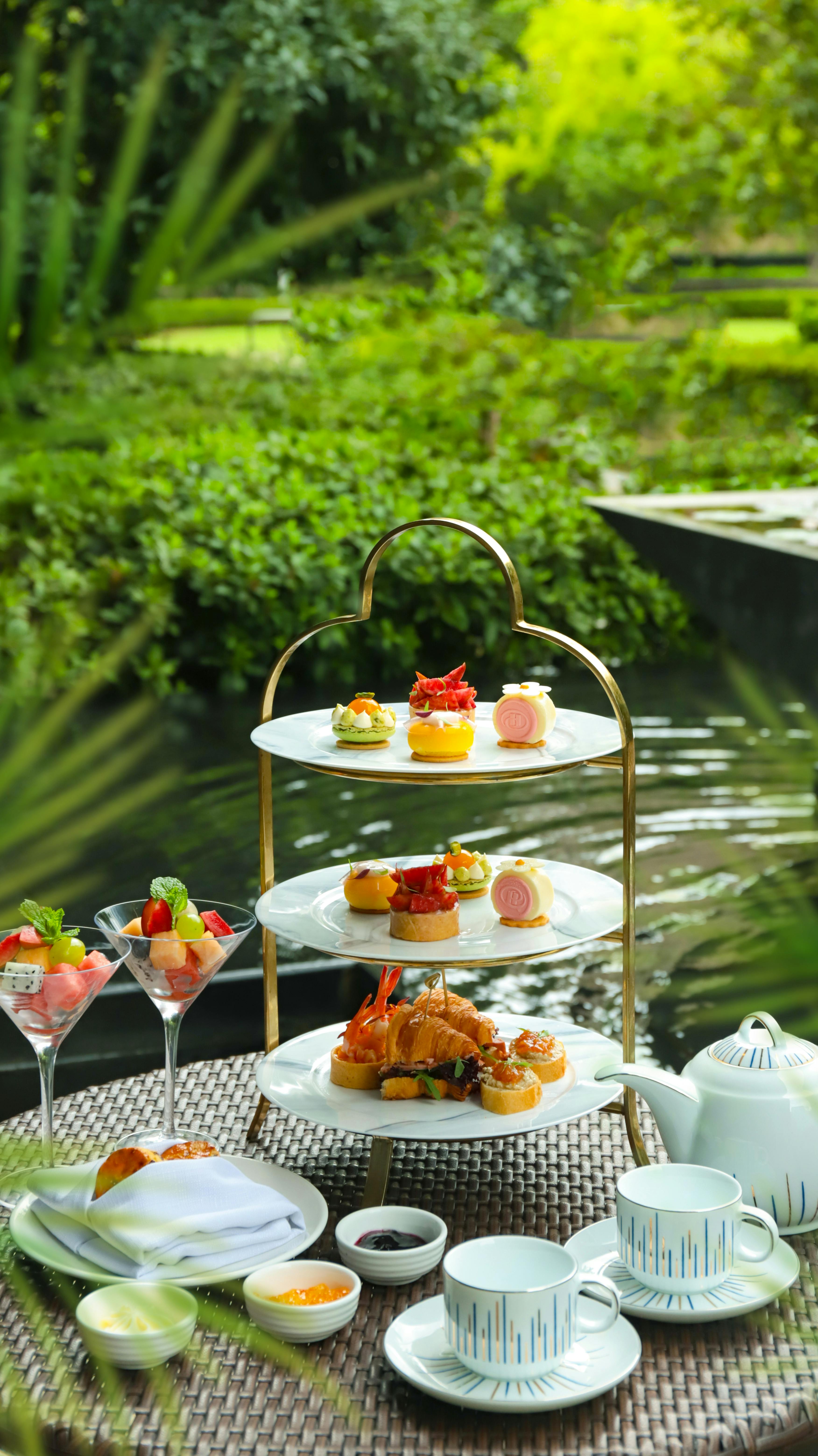 A tea set with three tiers of food and drinks · Free Stock Photo